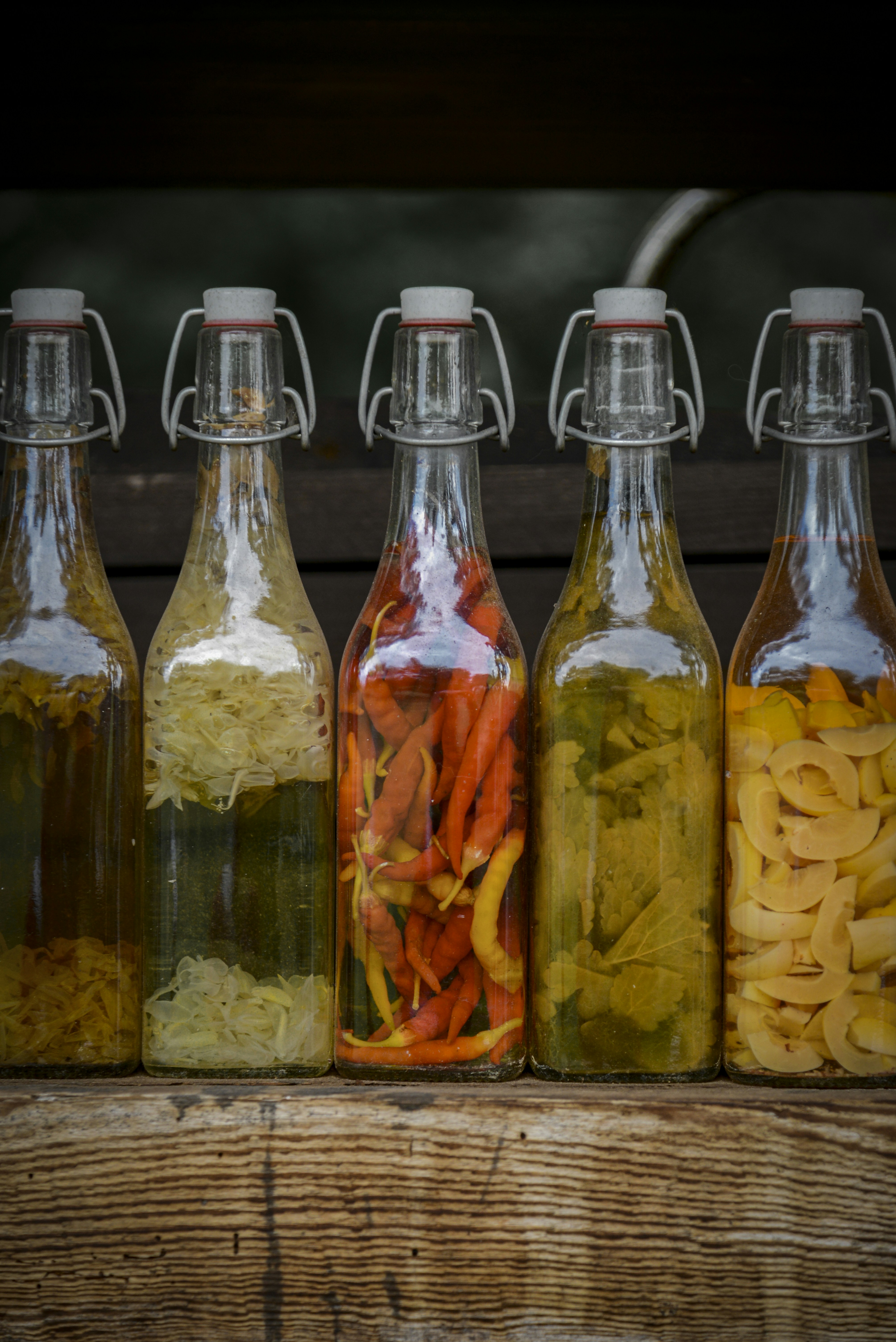 Row of Pickled Bottles: Colorful Chillies and Vegetables in Glass