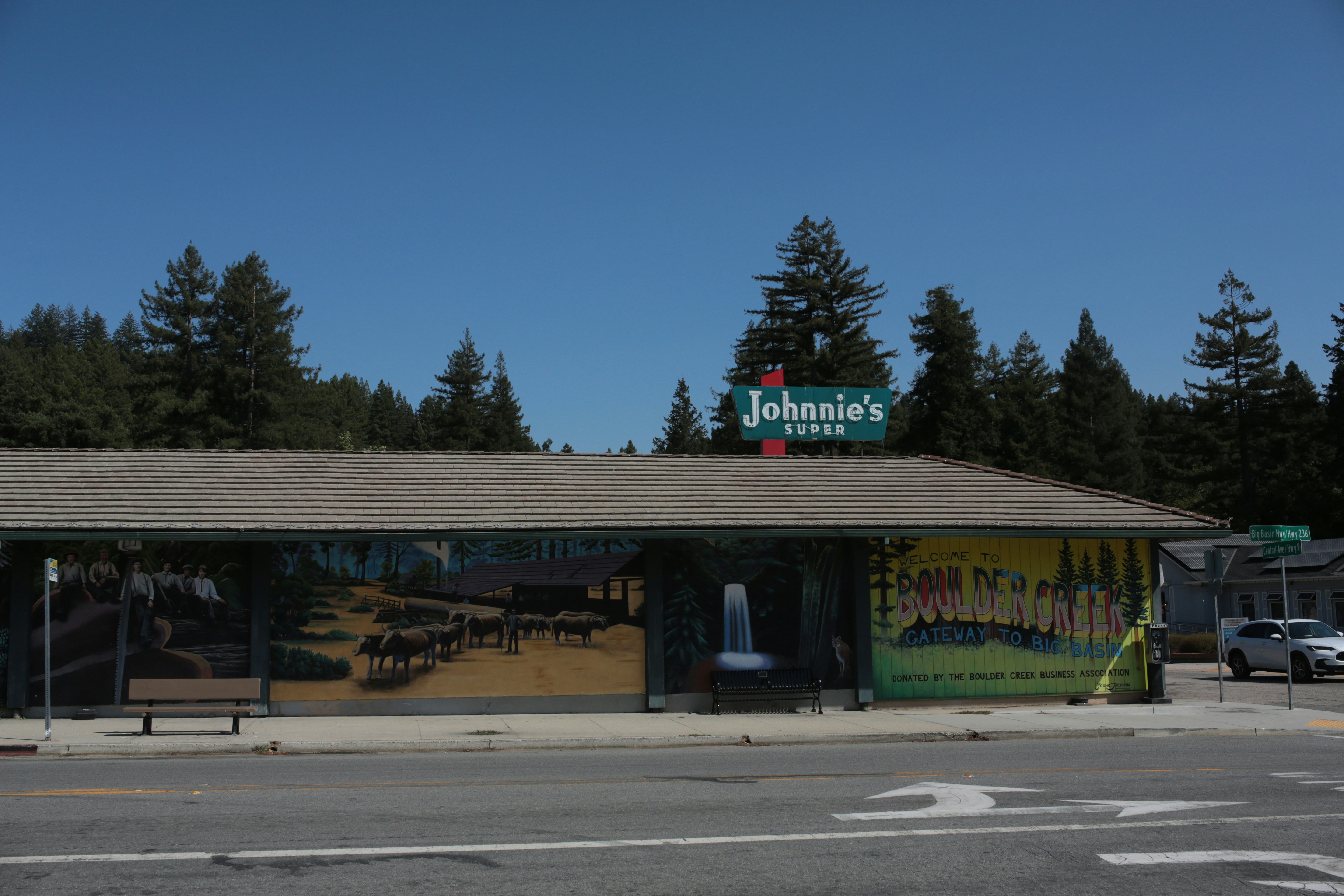 Mural-adorned storefront of Johnnie's Super, showcasing vibrant local art and a welcoming atmosphere.