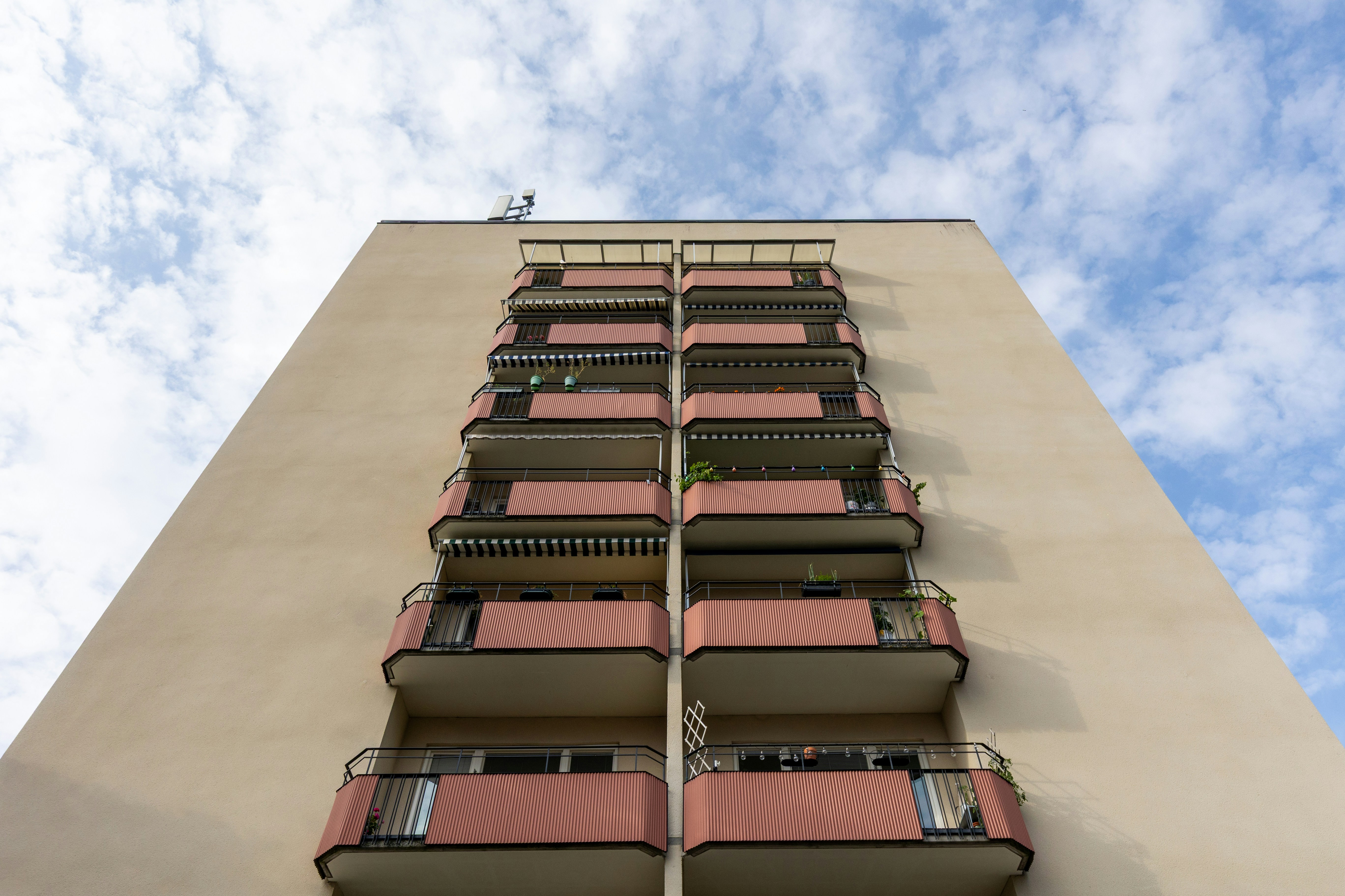 Tall building with balconies against a cloudy sky