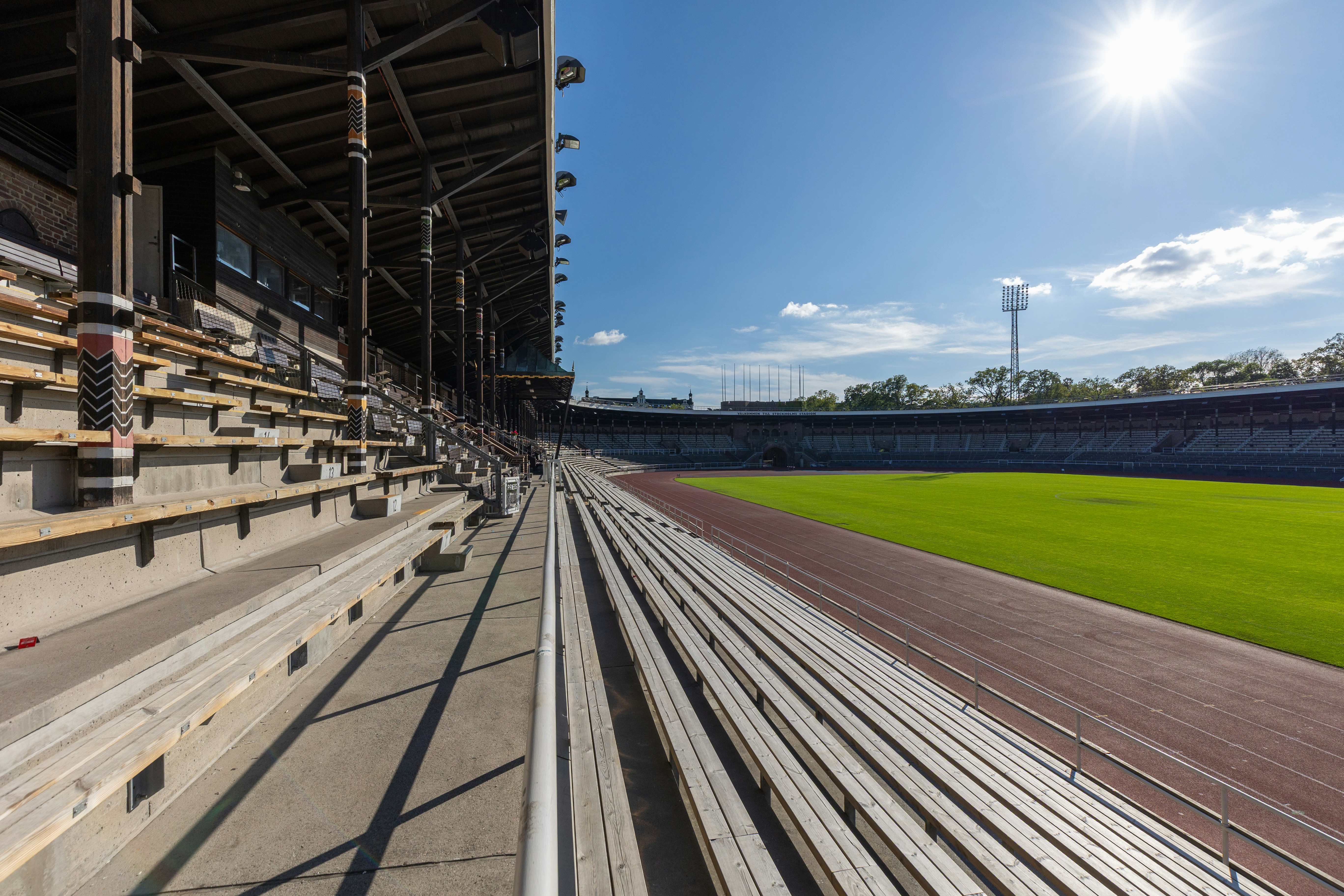 Empty stadium seating and track under sunny sky