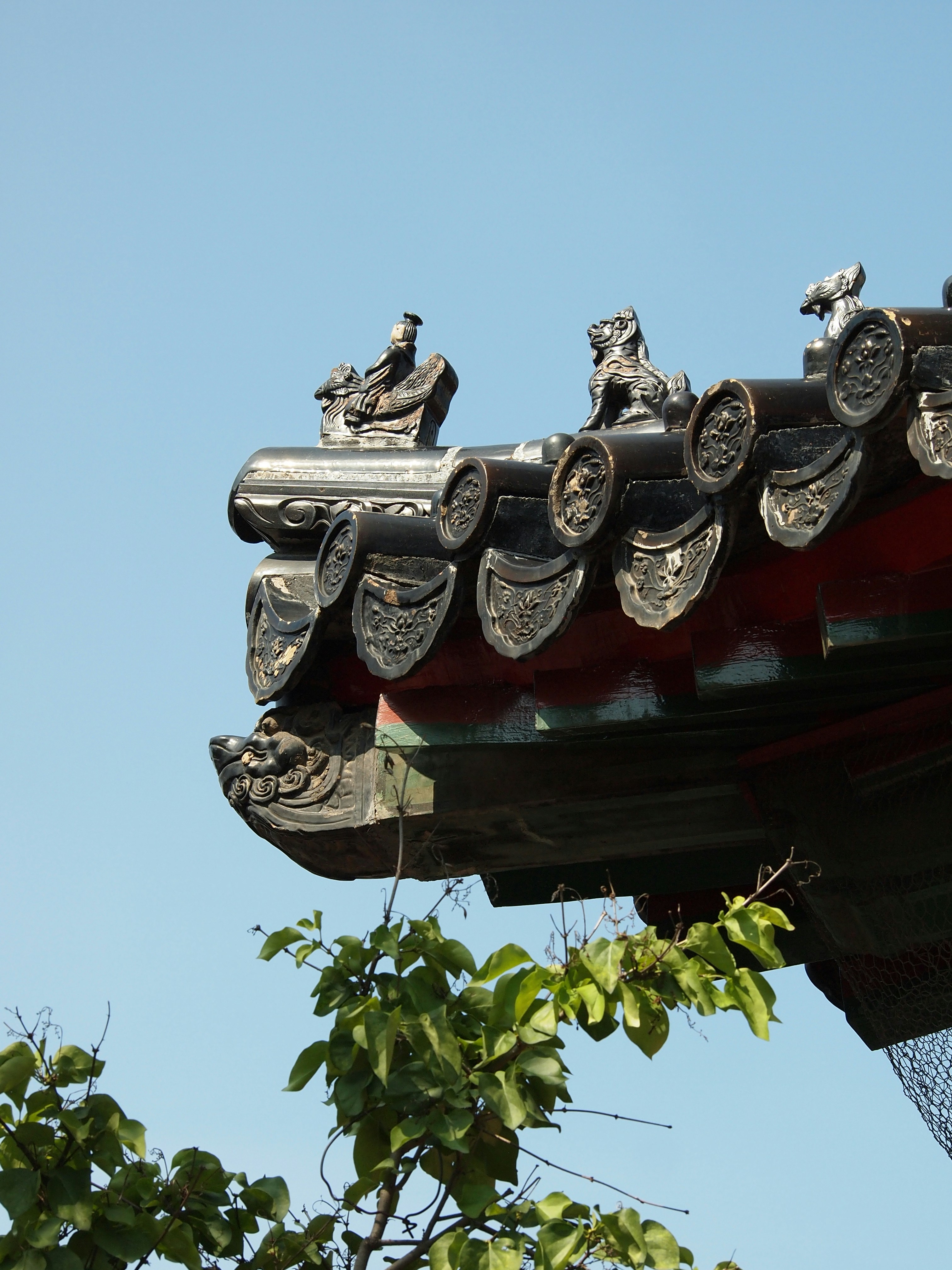 OLYMPUS DIGITAL CAMERA | Ornate roof detail against a clear blue sky.