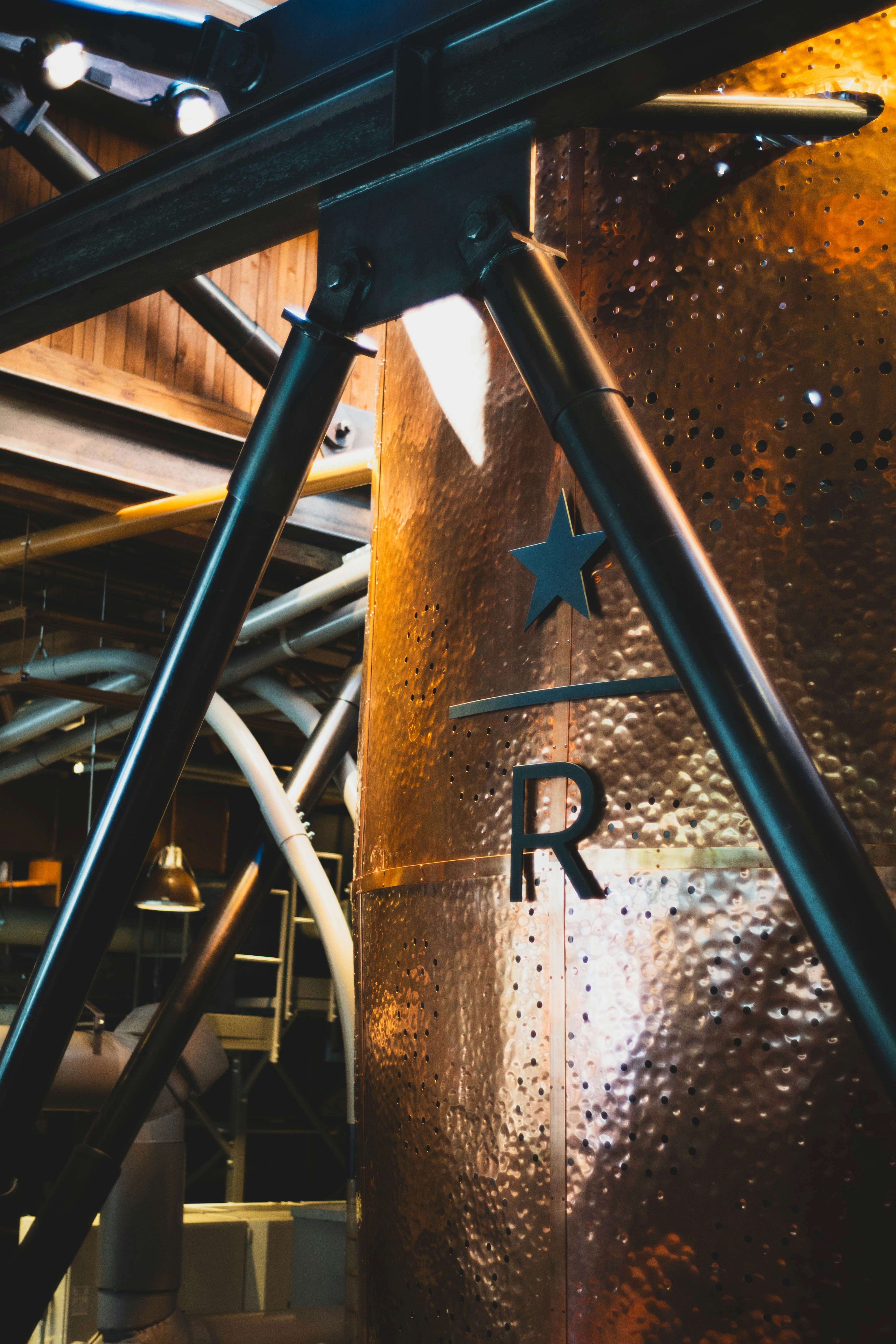 Star and R on a Hammered Copper Cylinder Framed by Industrial Trusses
