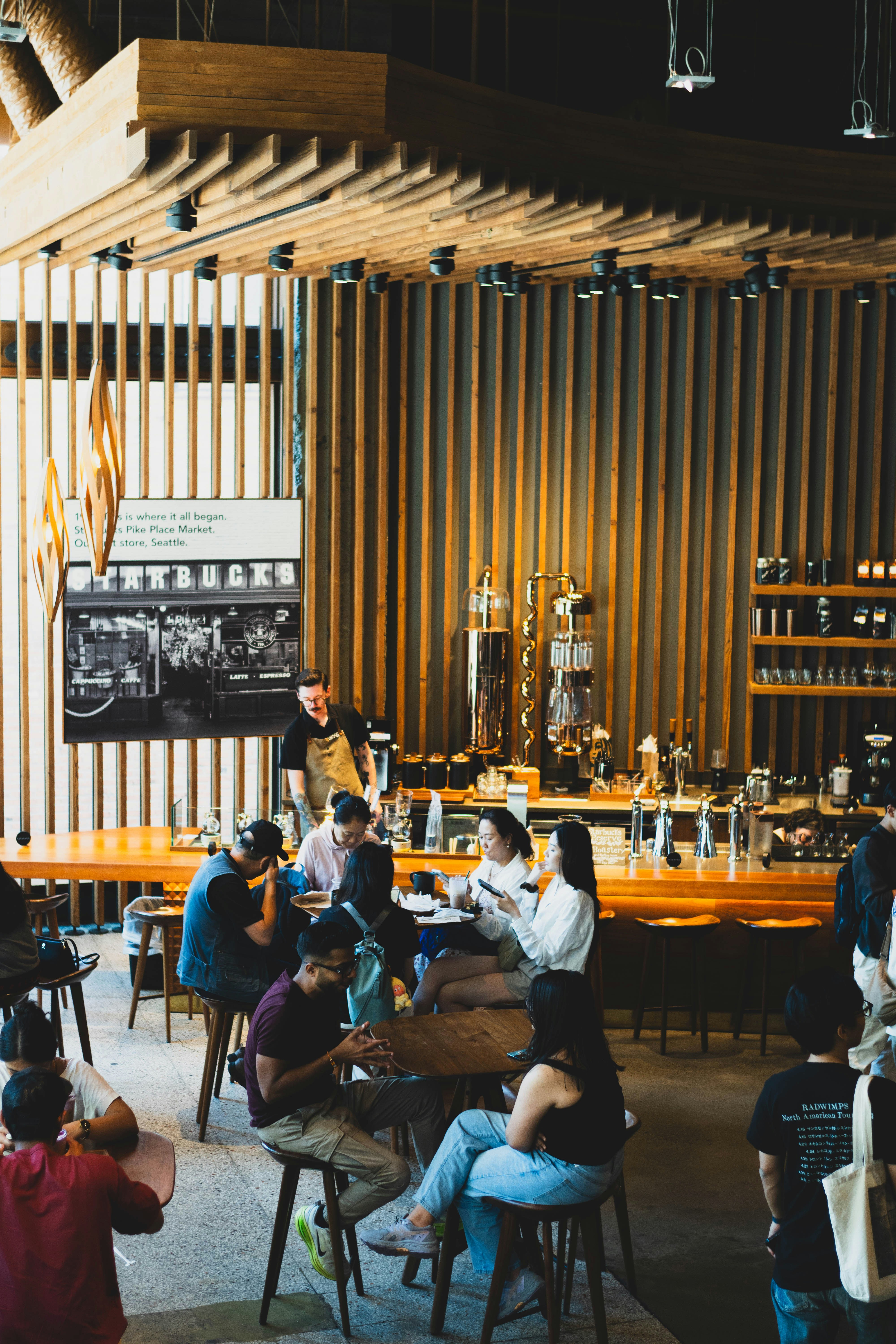 People sitting at tables inside a modern cafe photo – Free Woman Image ...
