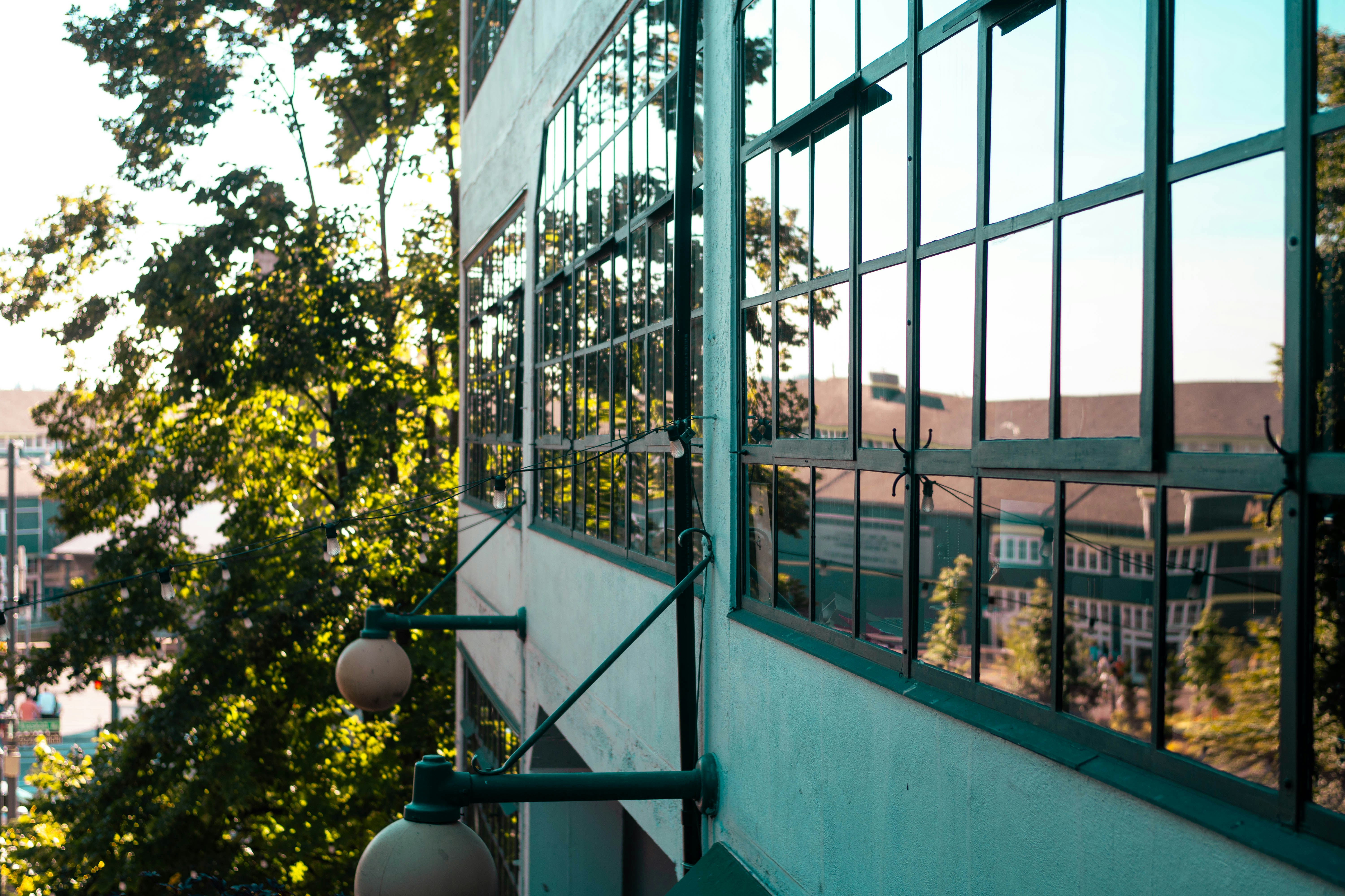 Modern building with glass windows reflecting sky and trees.