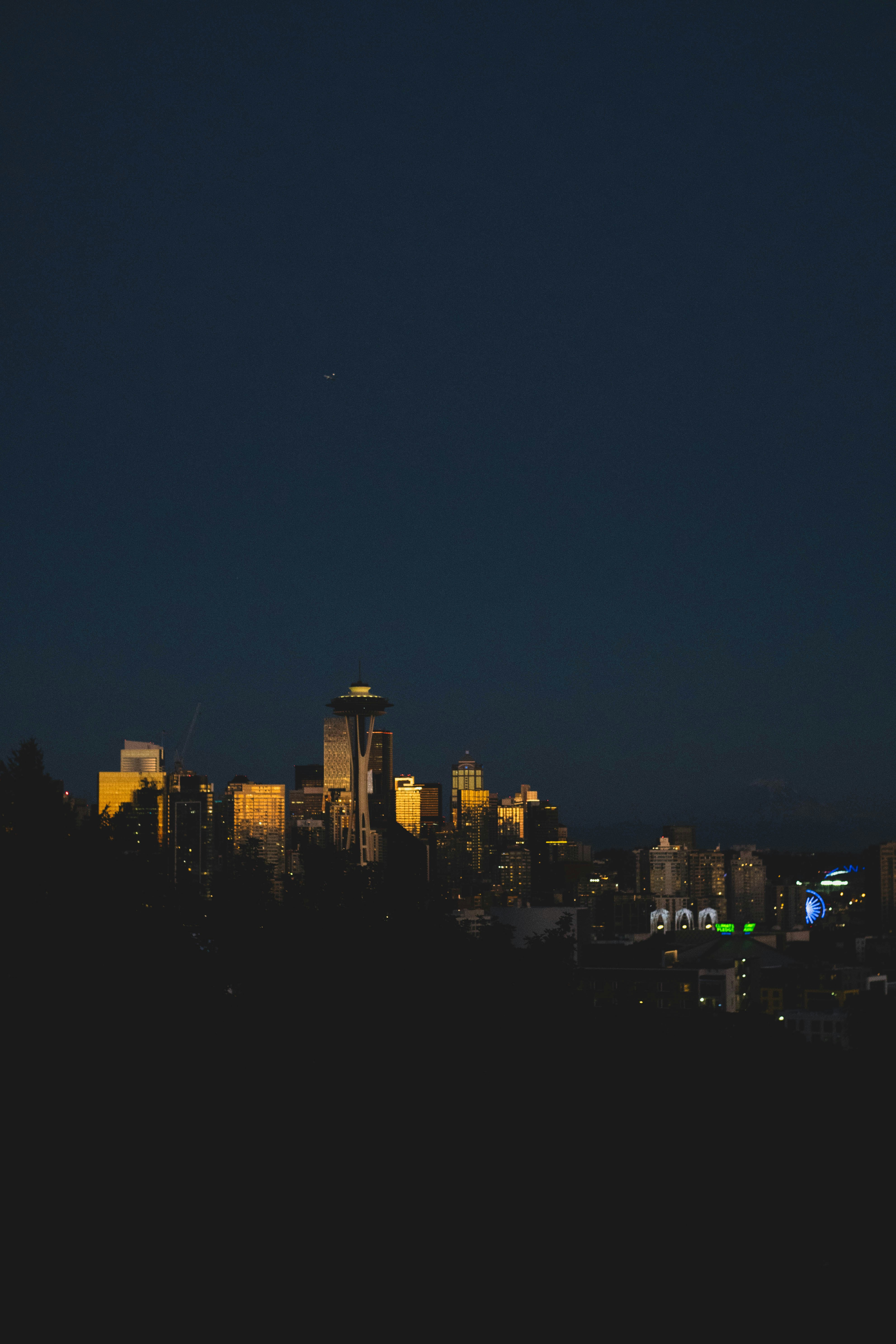 City skyline illuminated at dusk with dark foreground.