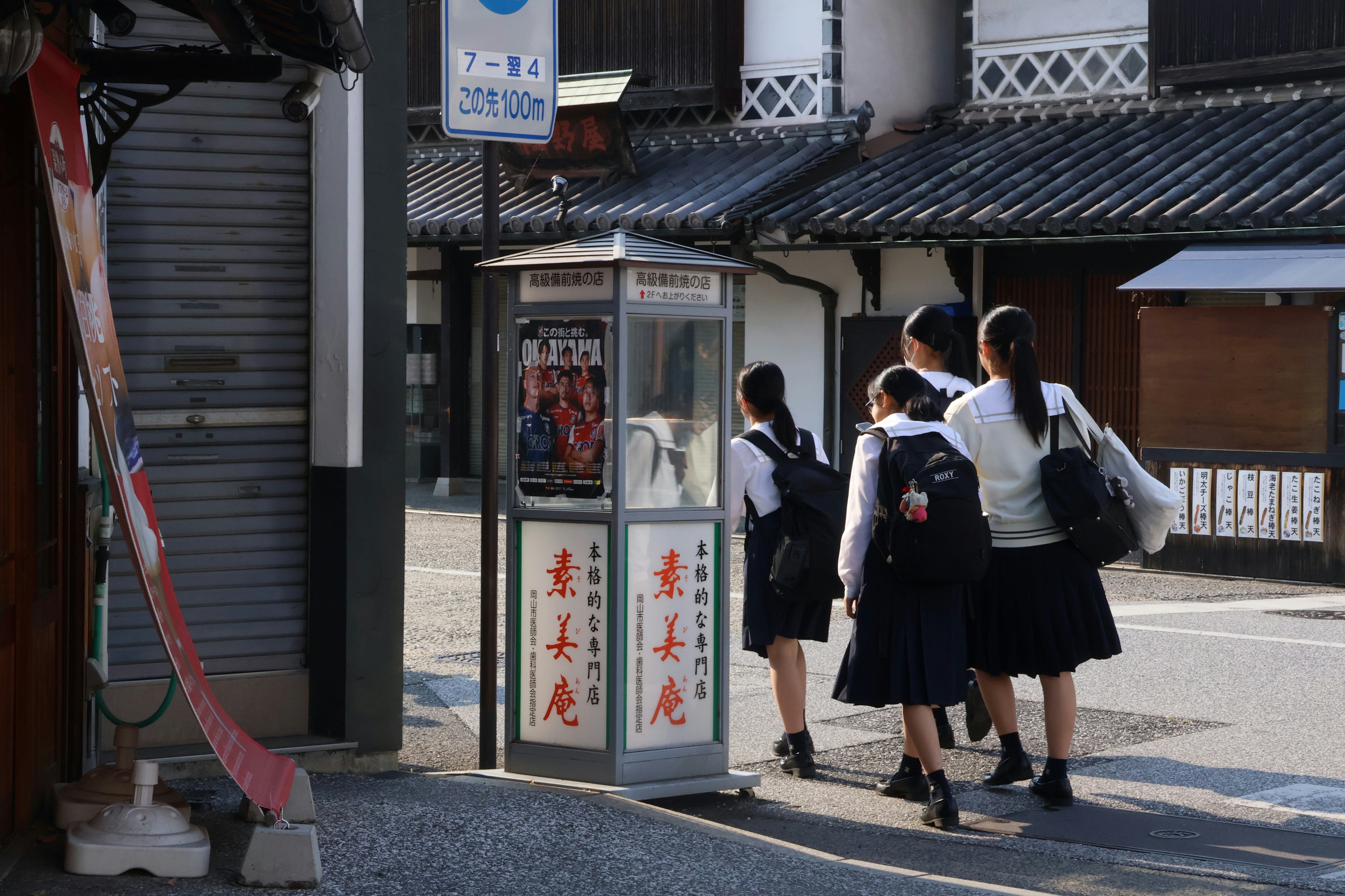 Students walking past a bus stop in japan