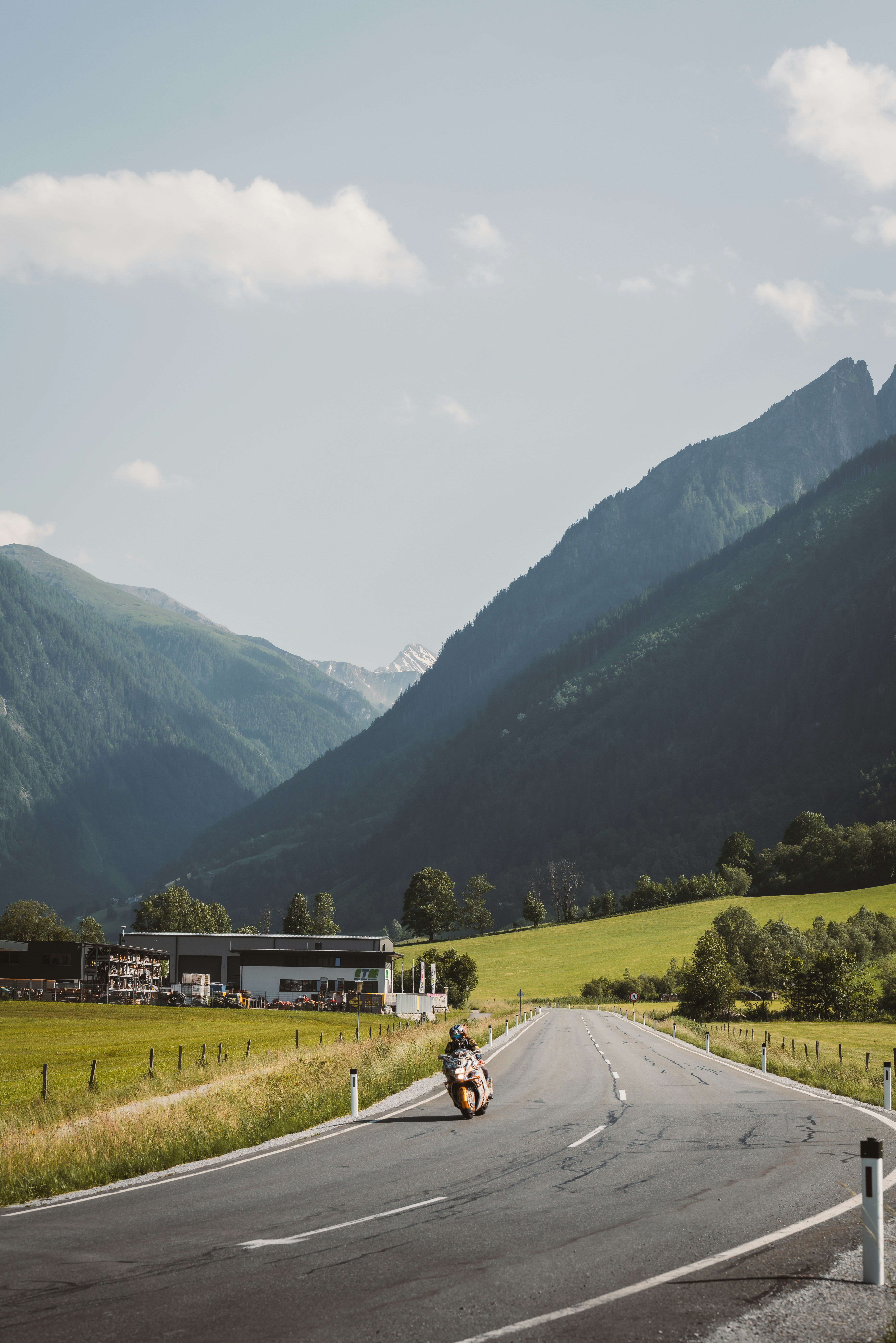 Serene Motorcycle Journey through Mountain Valley | Scooter rides on a scenic road through the mountains.