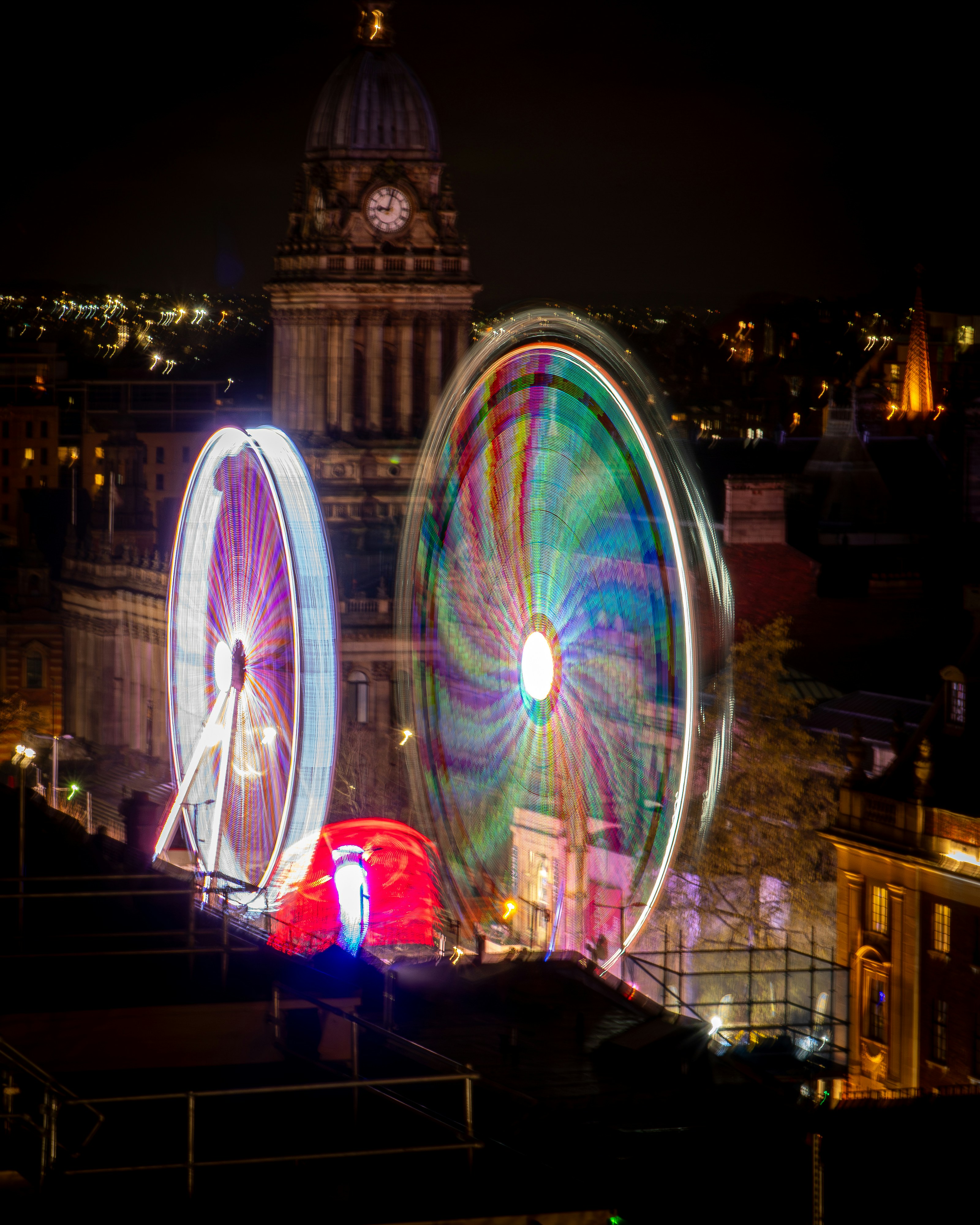 Ferris wheels illuminated at night with cityscape background cityscape background cityscape background city lights
