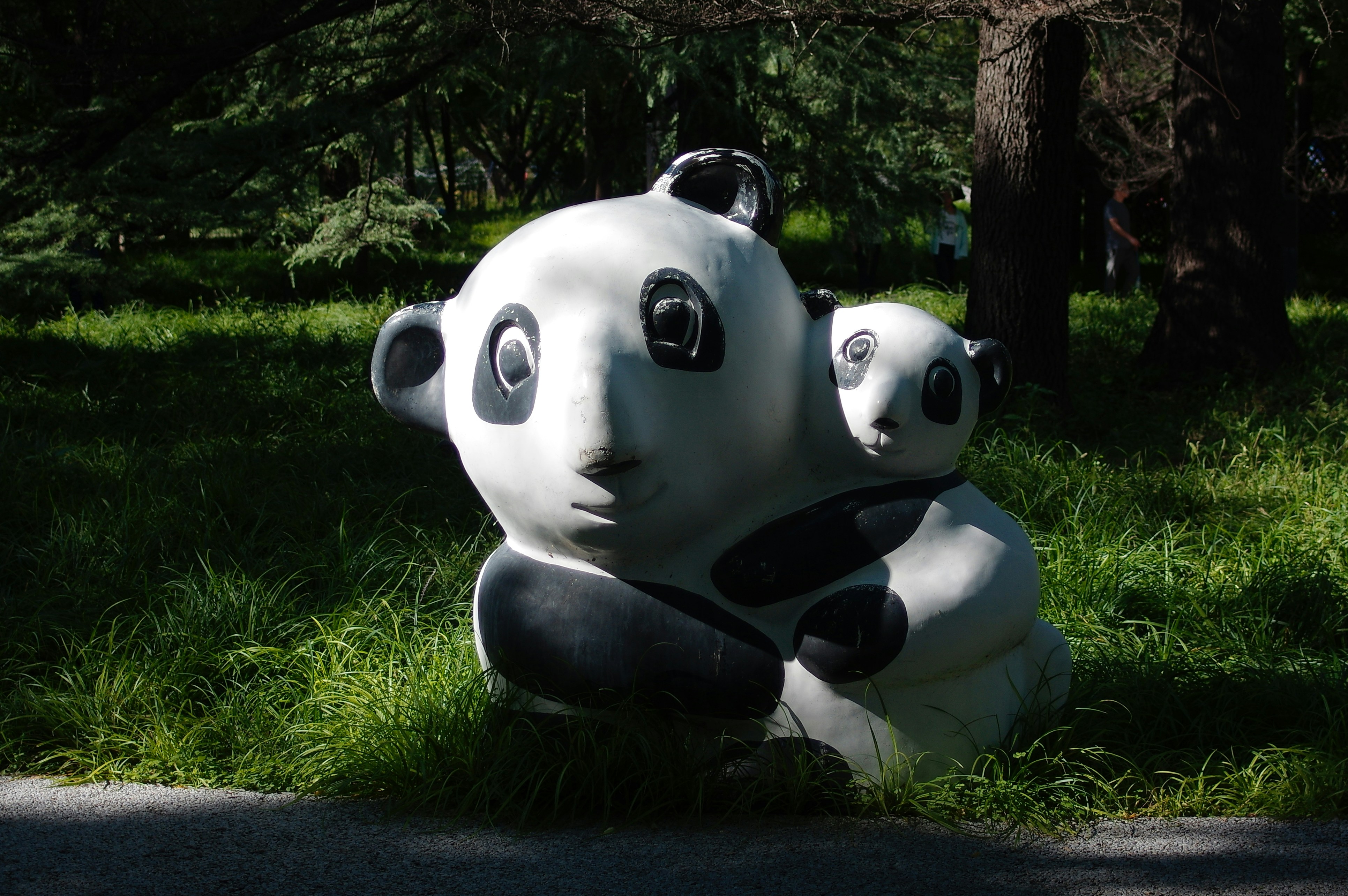 Two panda statues in a grassy park area