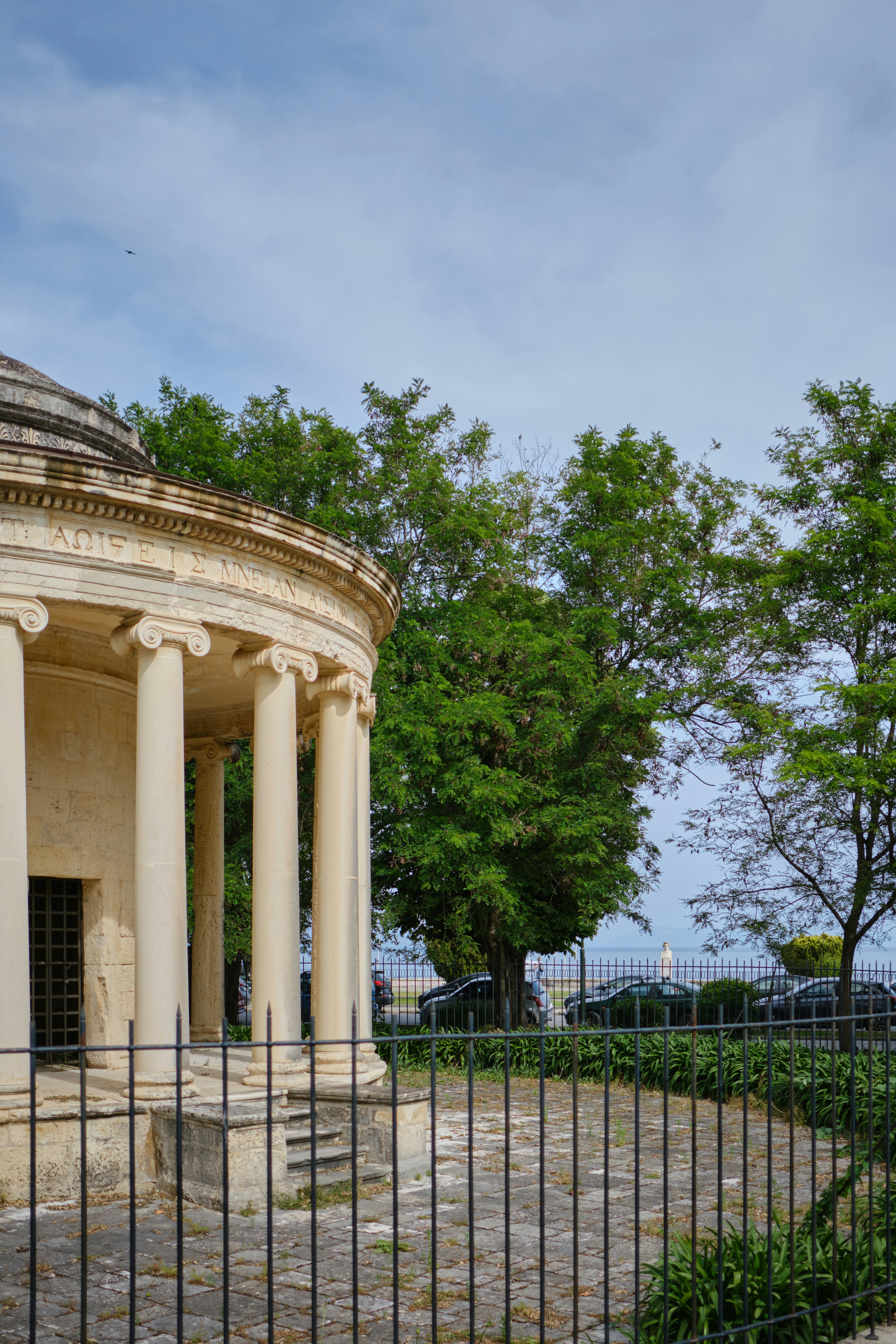 Classical building with columns and trees by the sea