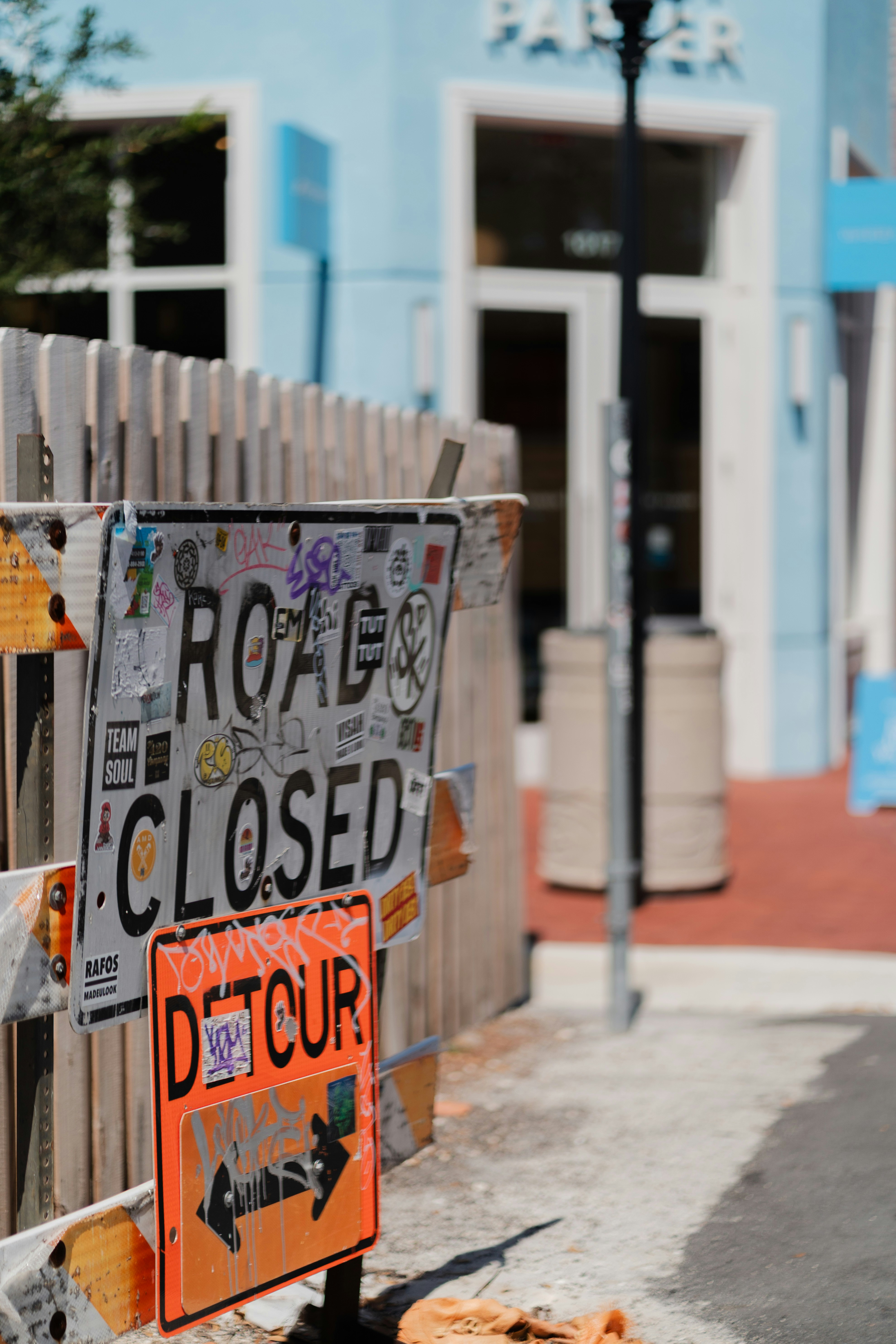 Construction Fence Canvas: Street Graffiti and a Blue Urban Entrance
