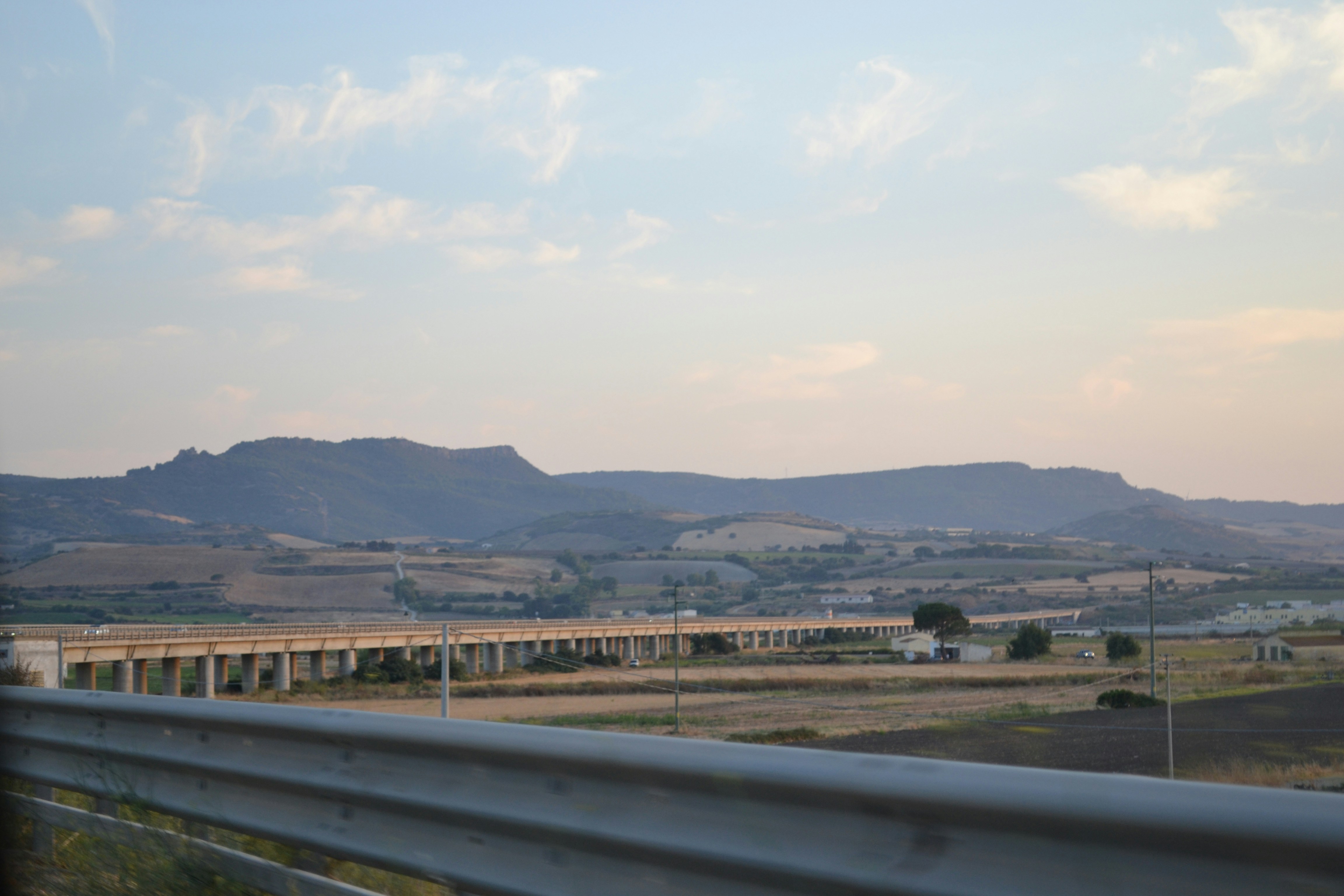 Highway overpass with rolling hills and mountains.