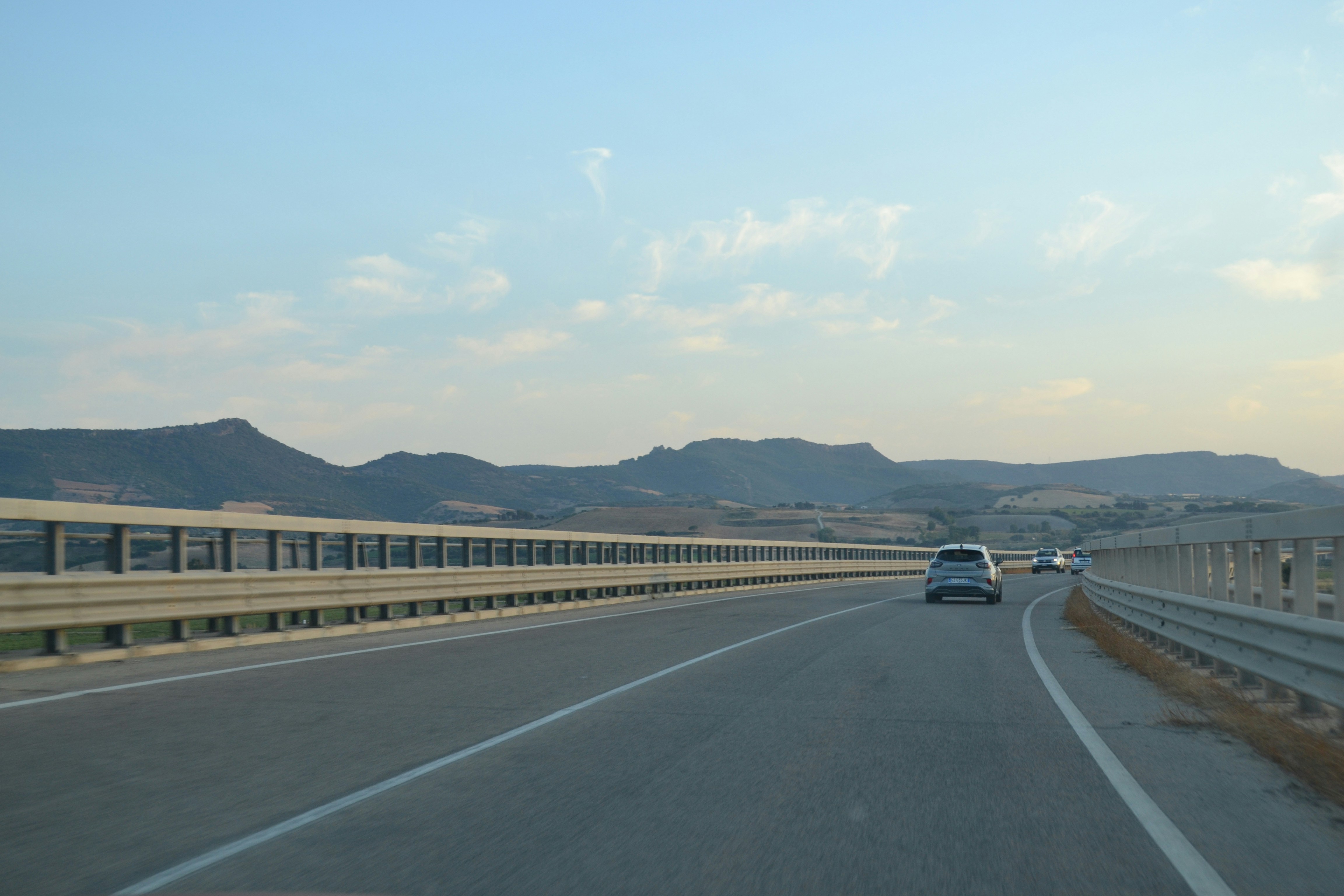 Cars driving on a highway with distant hills
