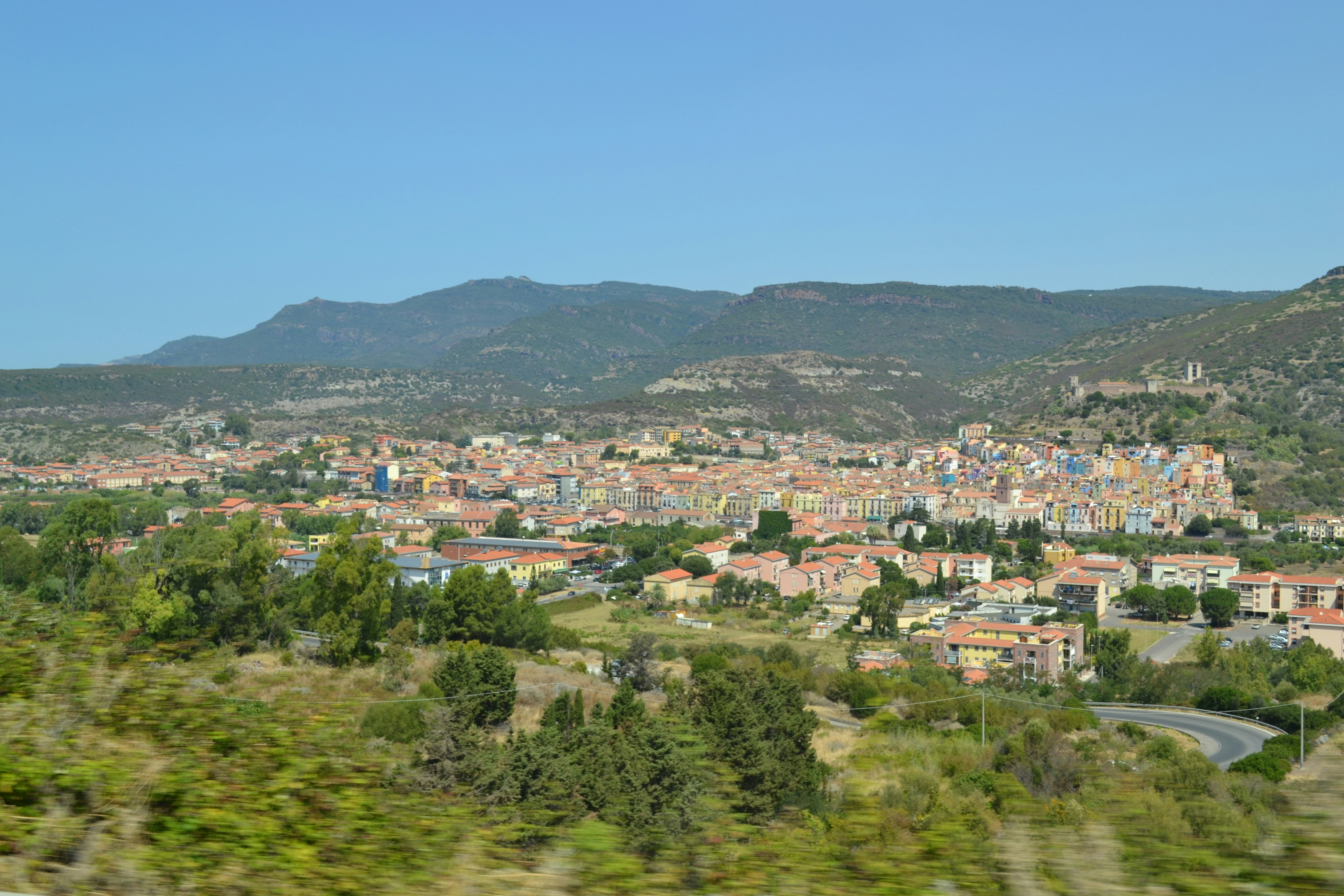 Town nestled in rolling hills under clear sky