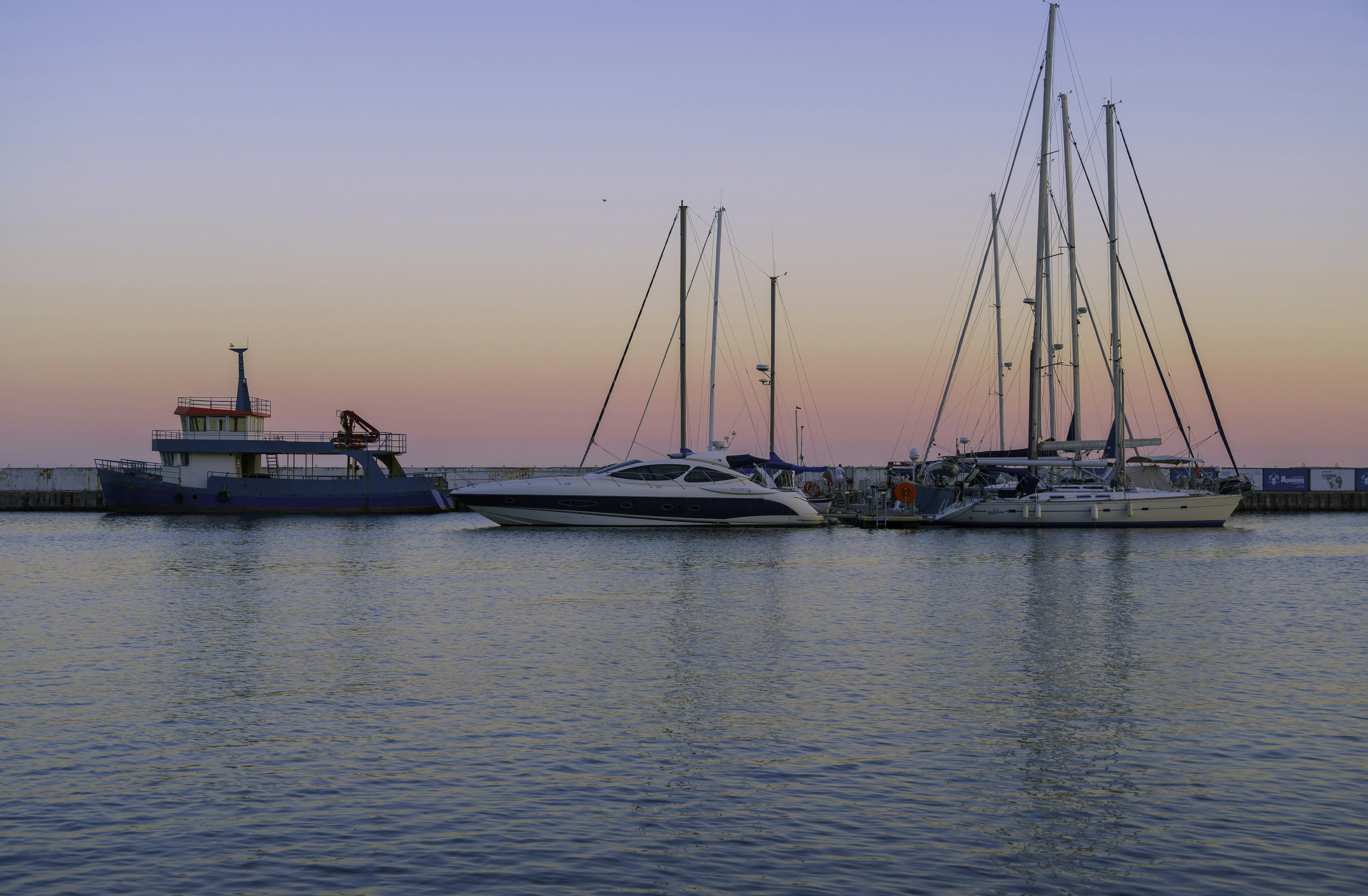 Balchik, Bulgaria | Sailboats and a boat docked in a harbor at sunset