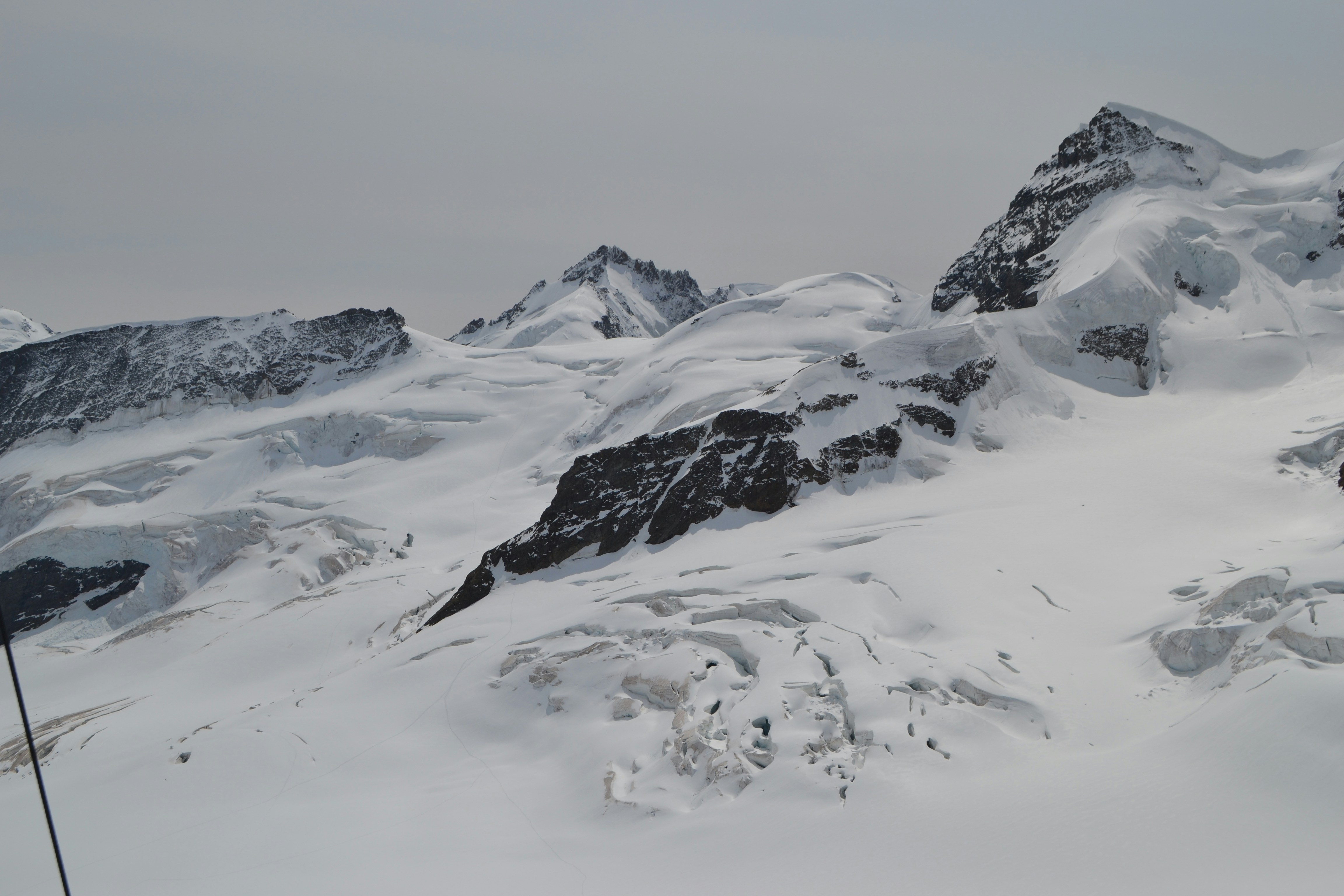 Jungfraujoch, Schweiz, Blick von der Aussichtsplattform | Snowy mountain range under a cloudy sky