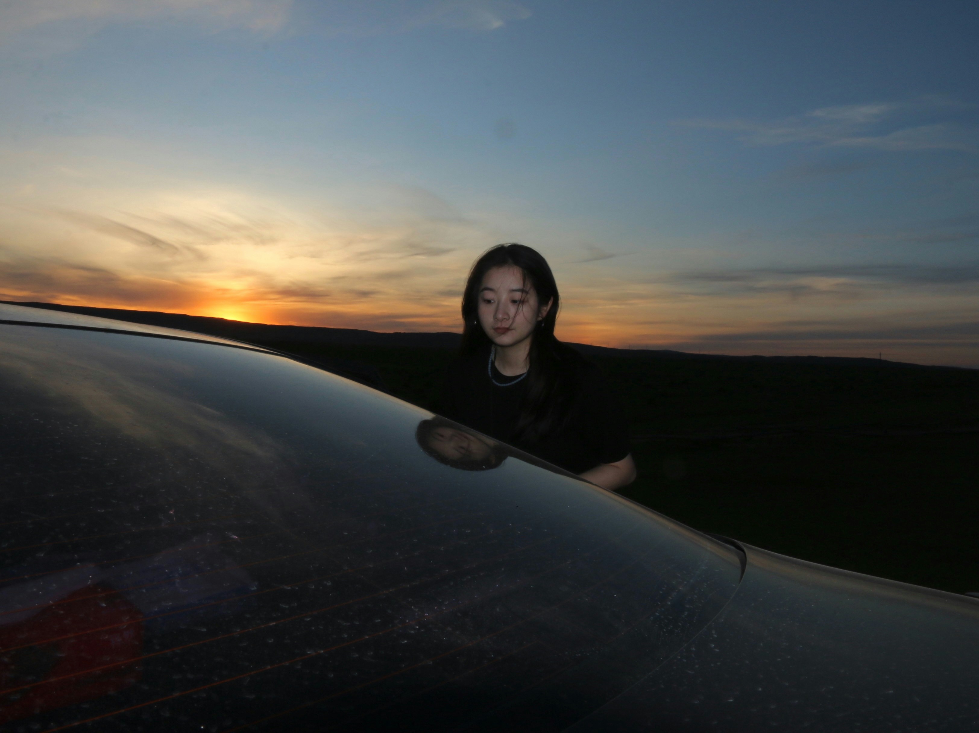 Ulanqab Grassland Sunset | Young woman looking down at sunset