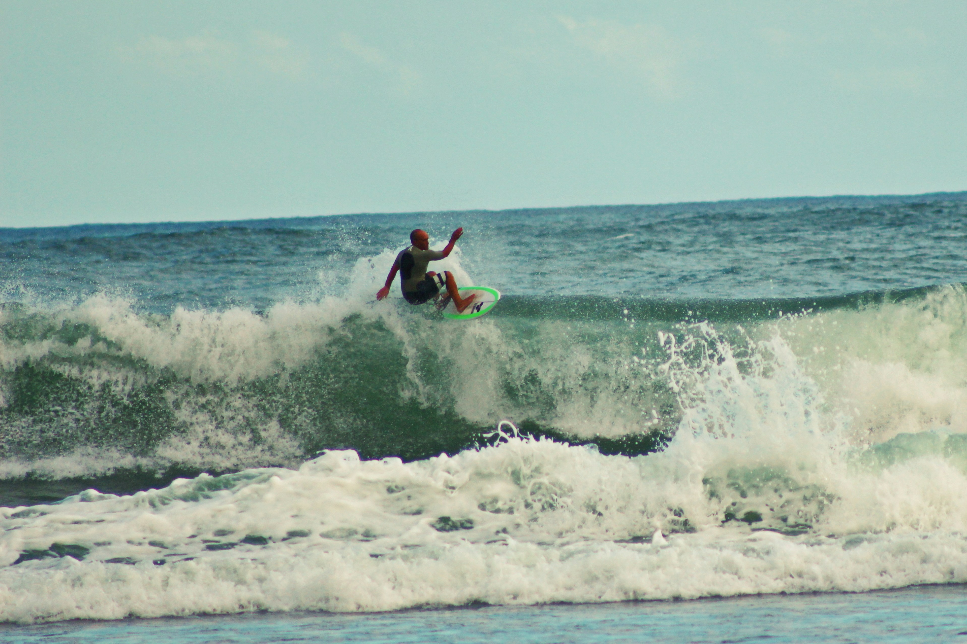 Surfer riding a wave on a sunny day