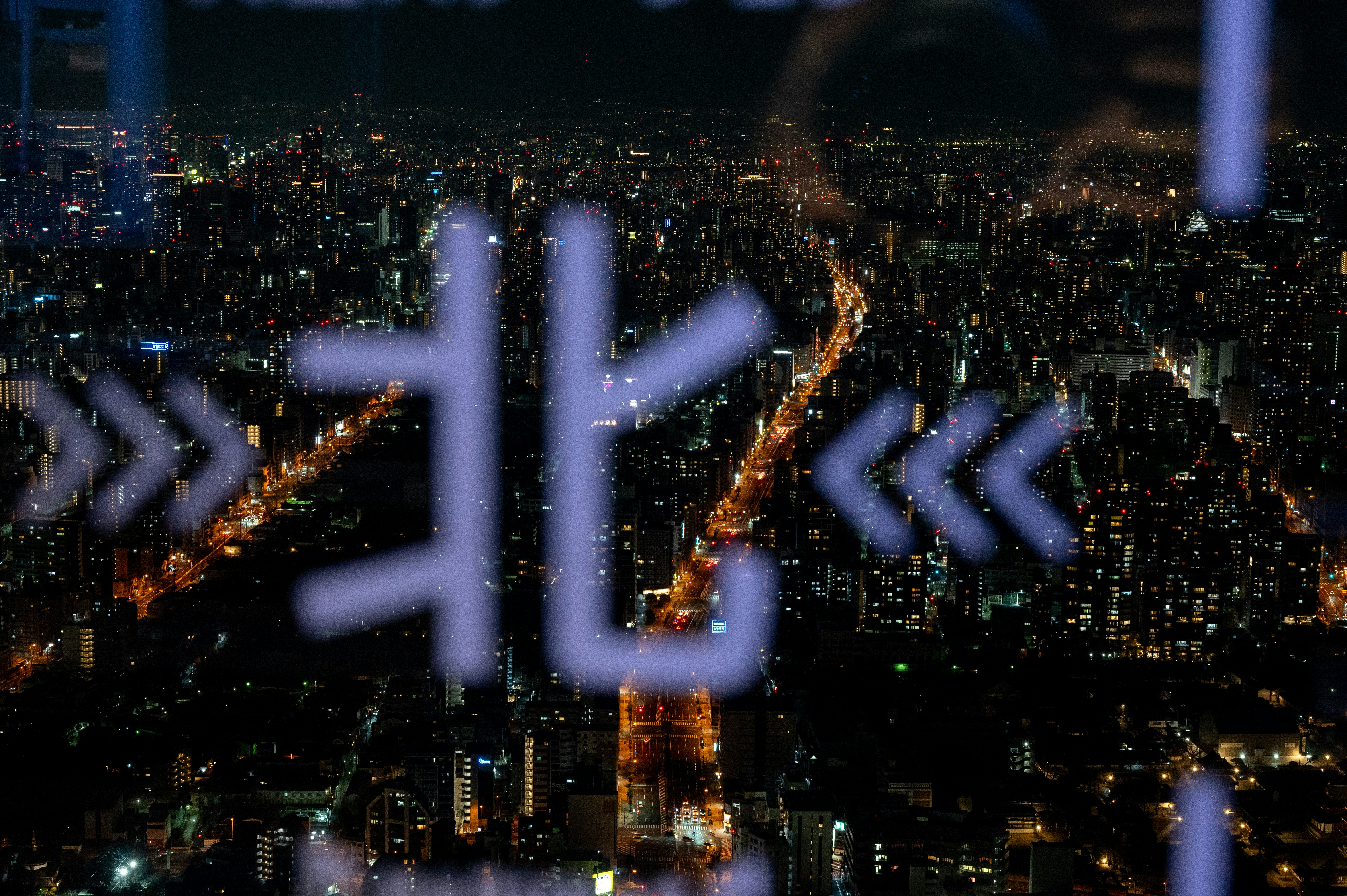 Nighttime cityscape with glowing japanese character