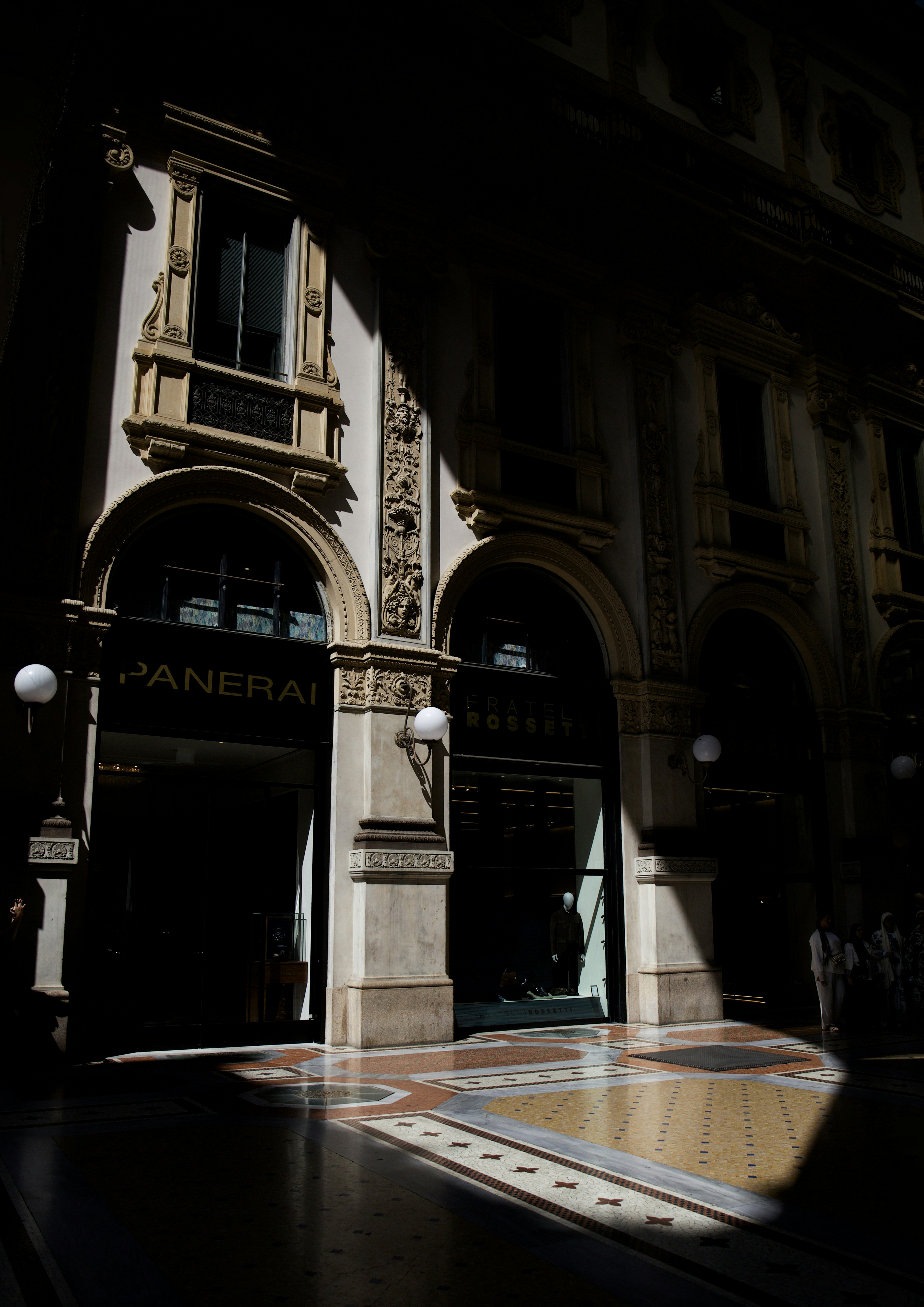 Sunlight streams through an arched building entrance.