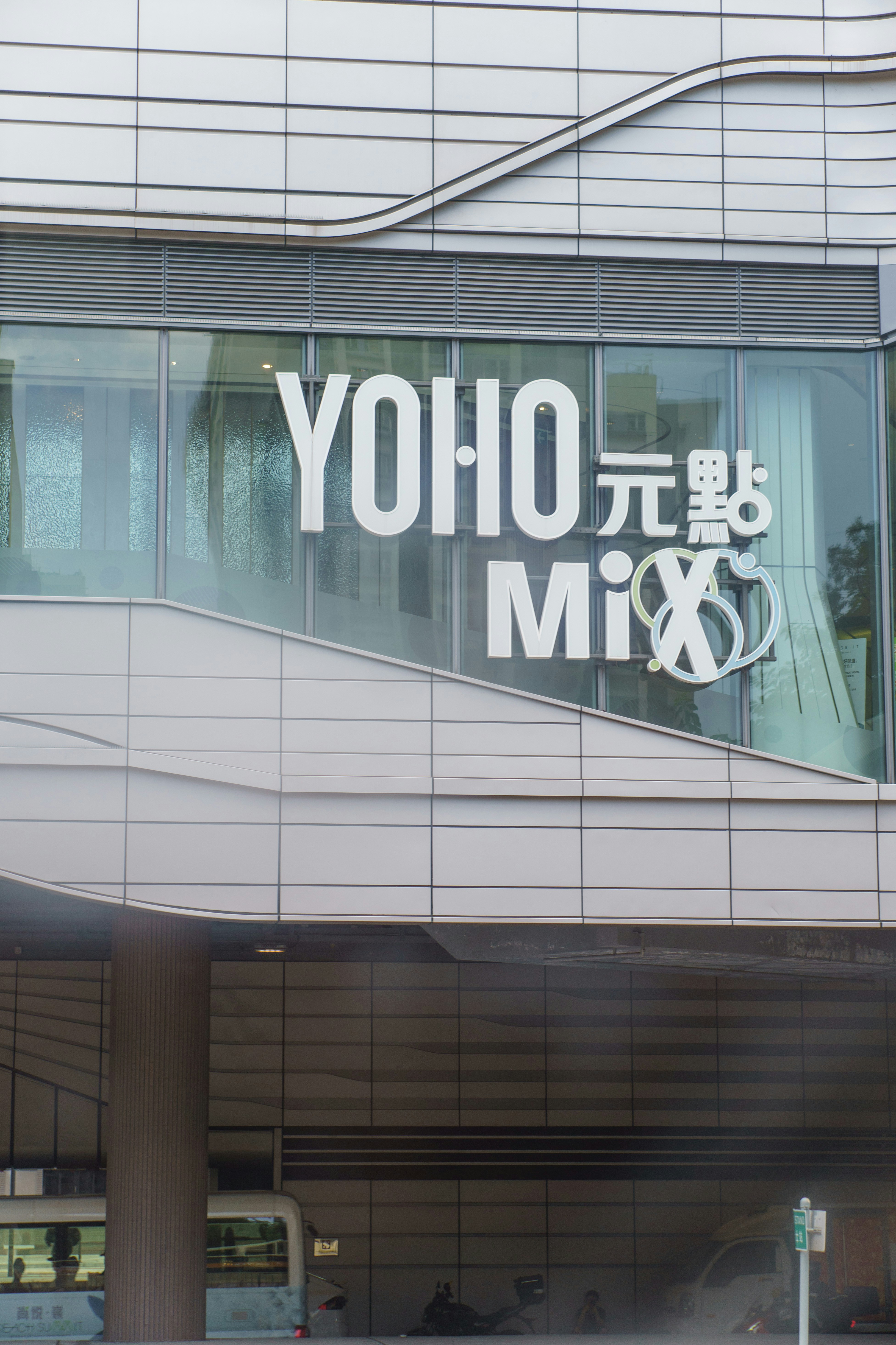 Stylized signage featuring 'YO!10元點 Mix' prominently displayed on a contemporary building facade.