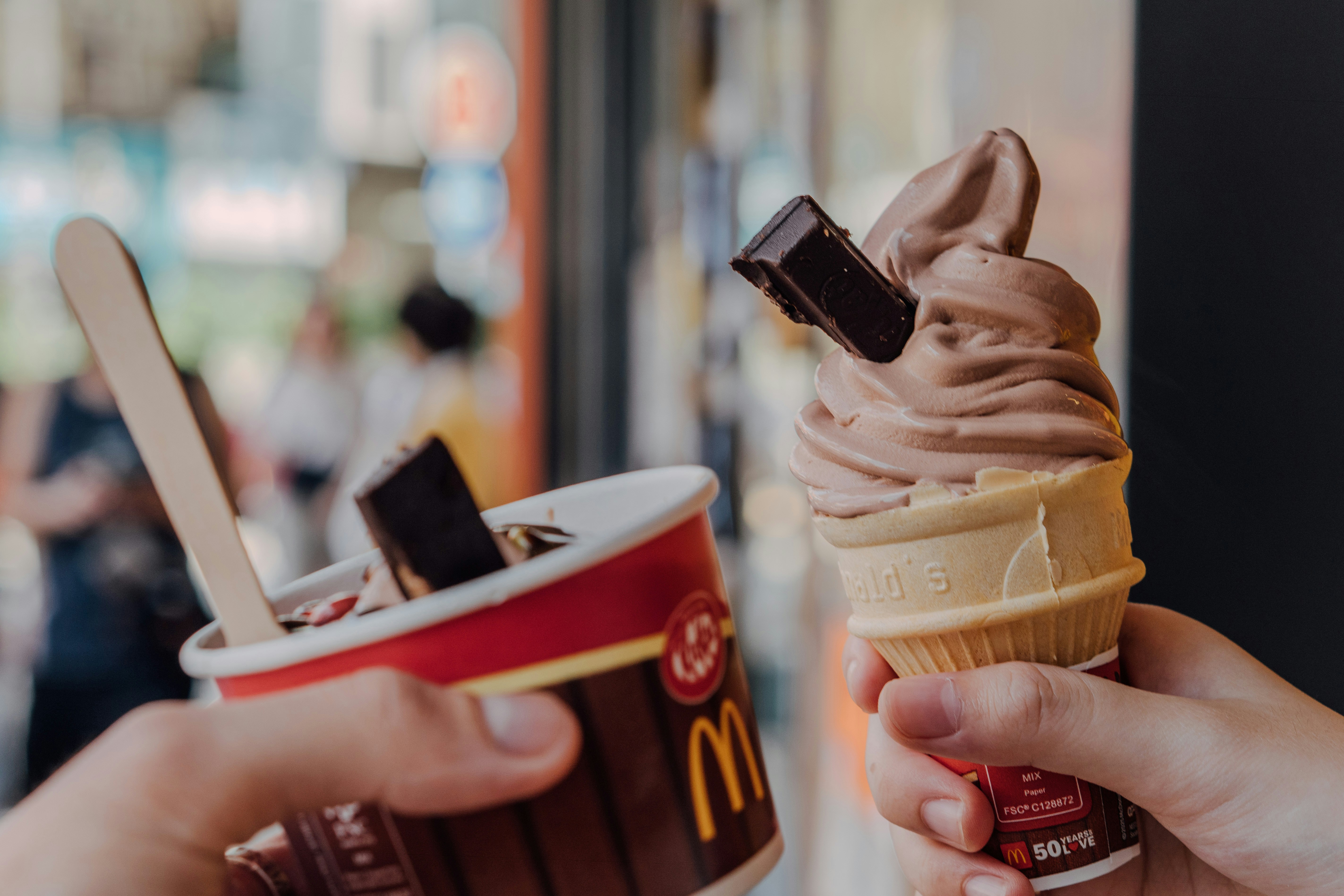 Two hands holding chocolate ice cream cones