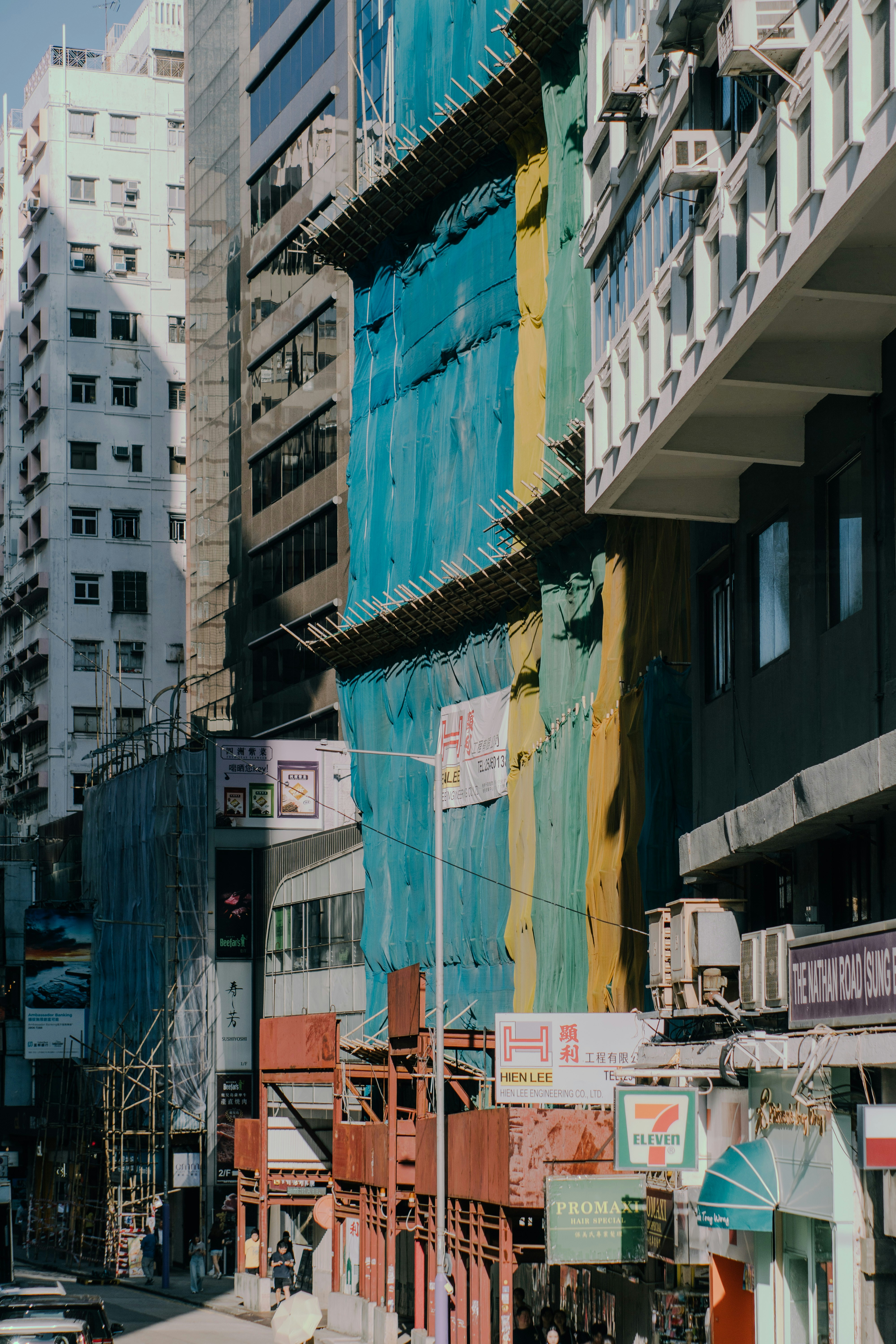 Buildings under construction with scaffolding and netting.