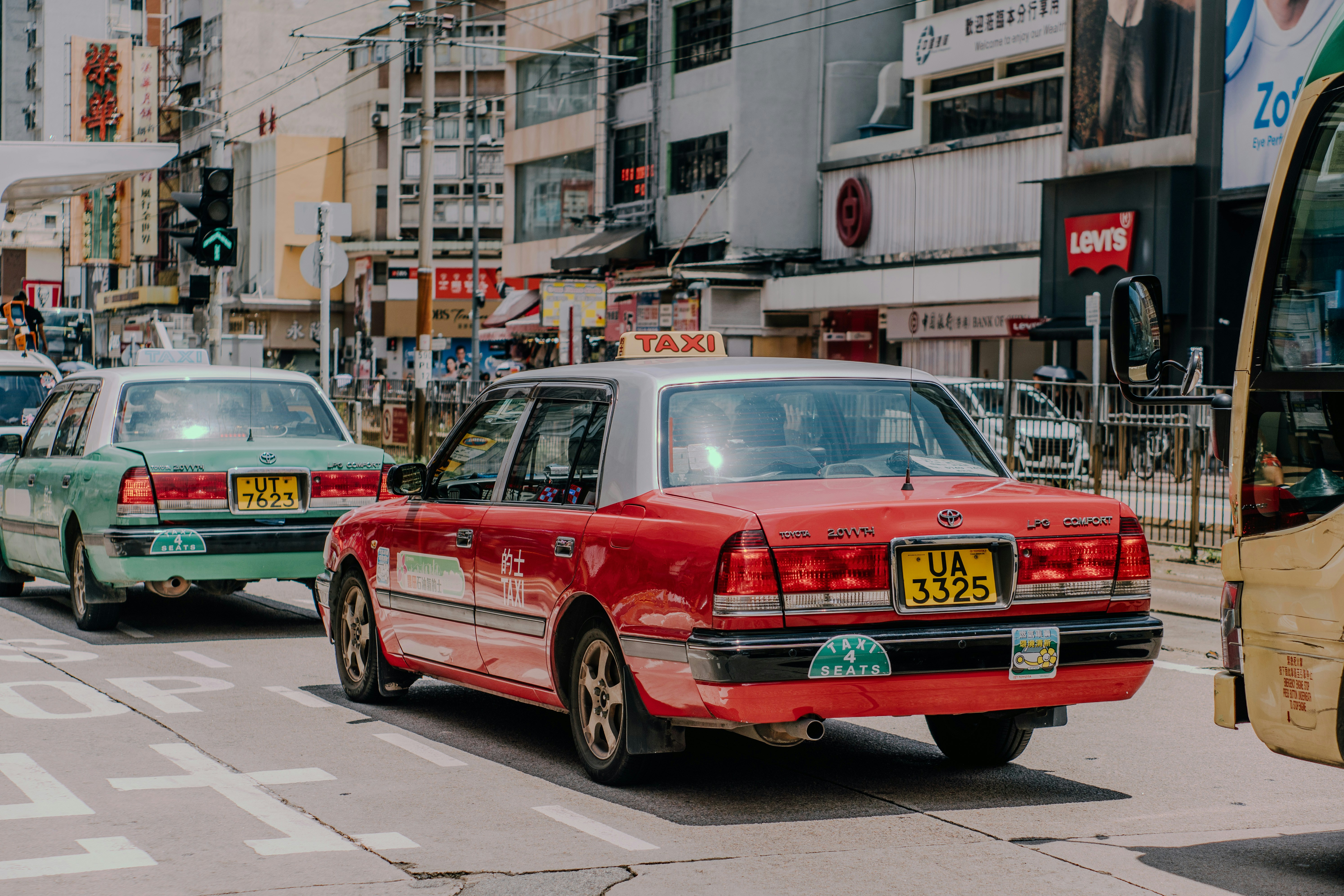 Red taxi driving on a city street.