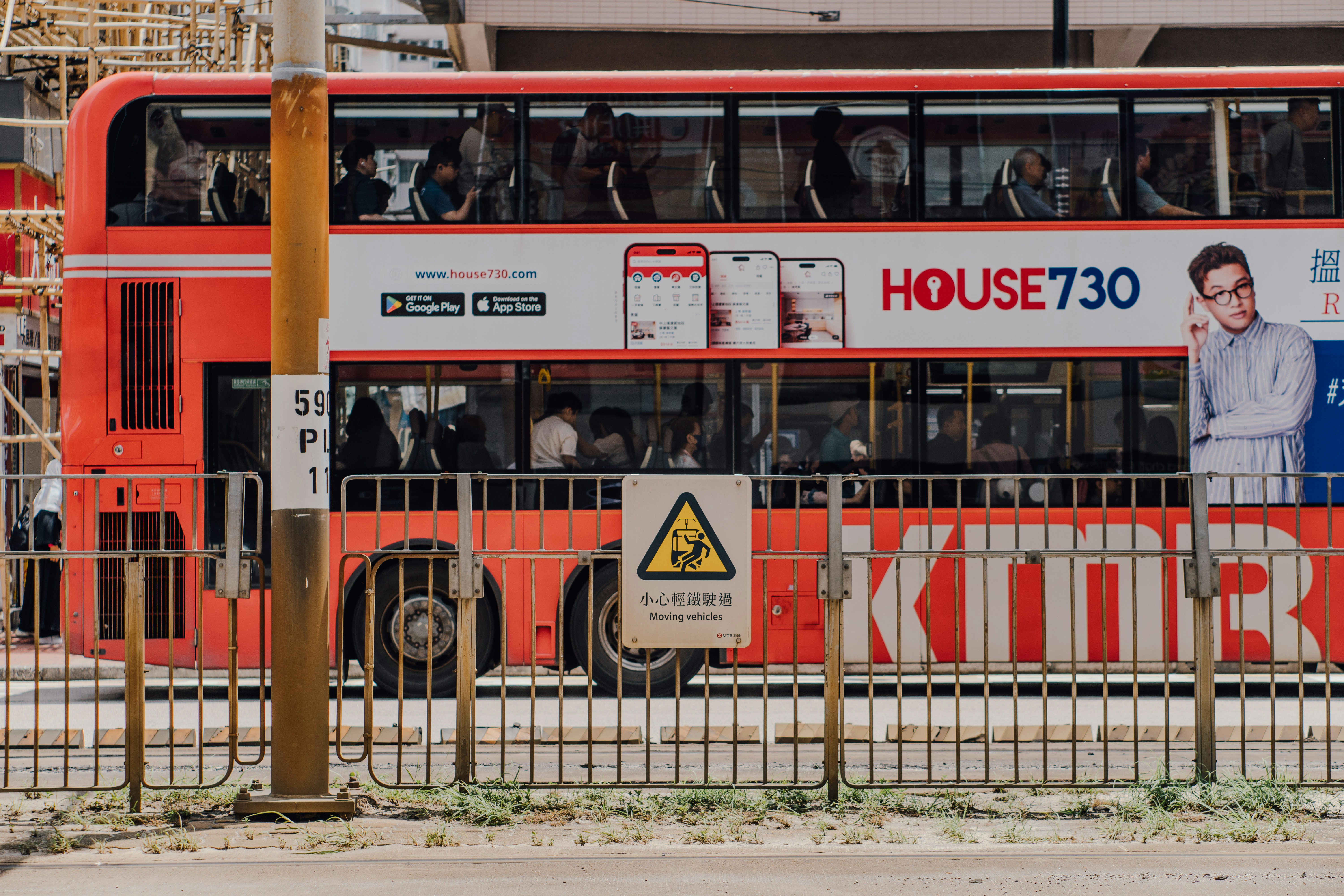 Red double-decker bus with advertisements on its side.