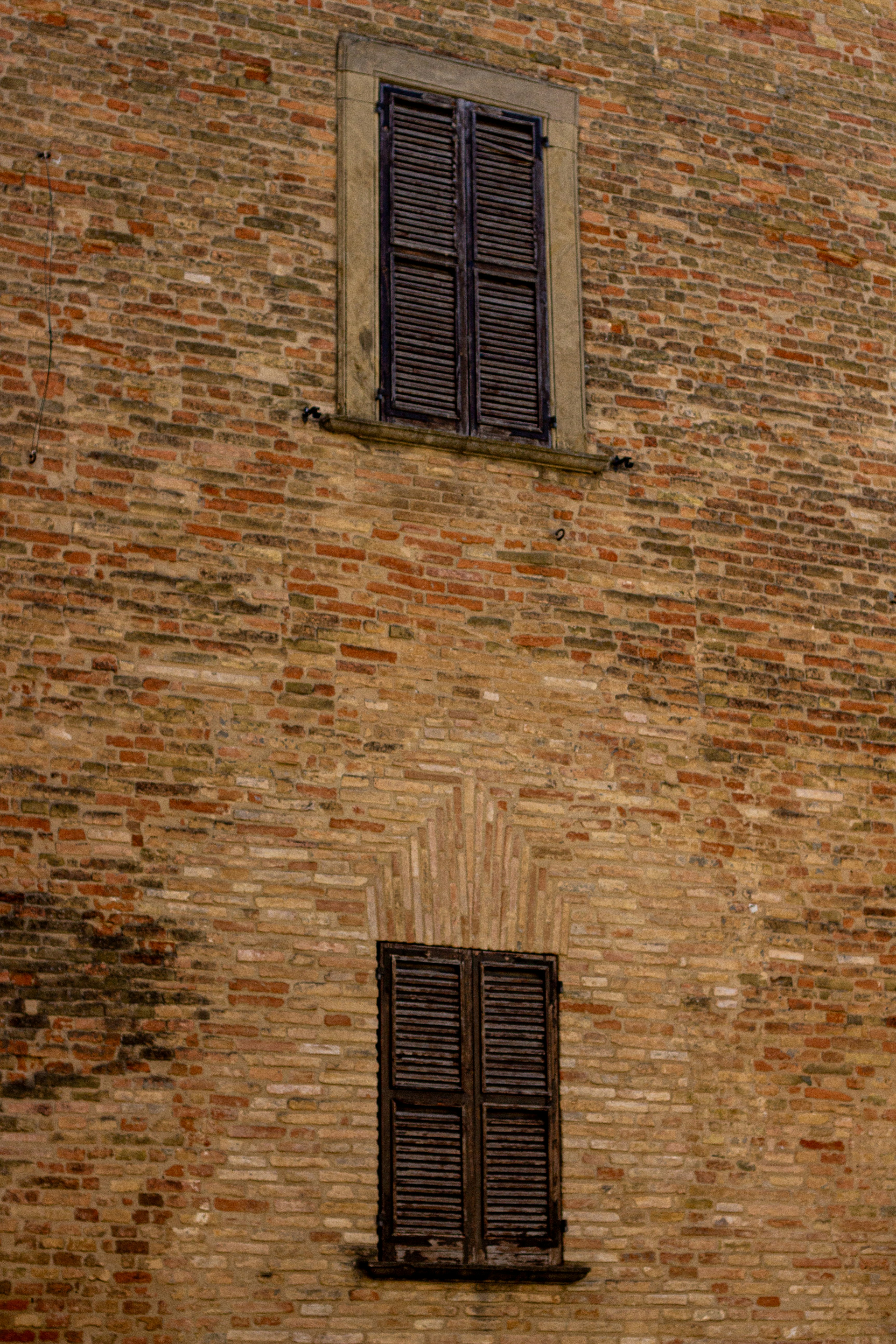 Two windows on a brick wall