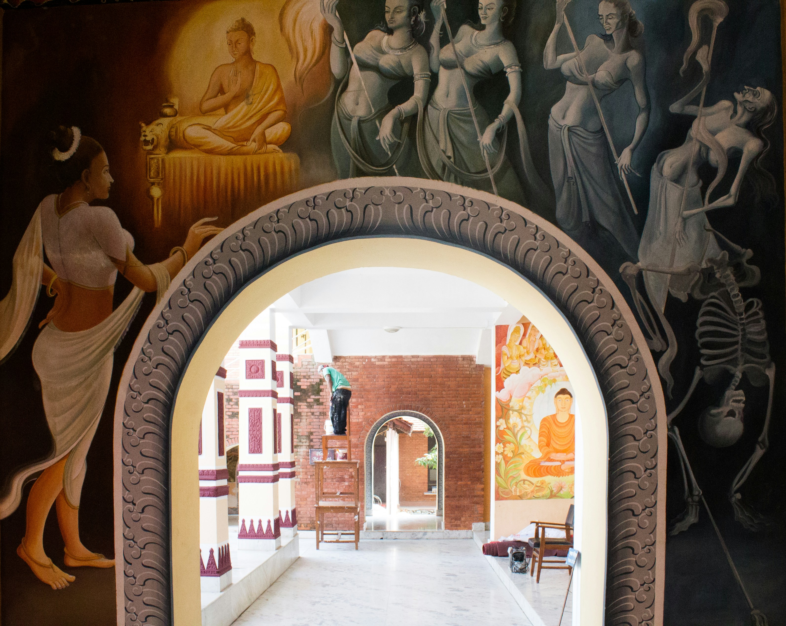 Art of the wall at the Lumbini | Archway revealing a courtyard with murals