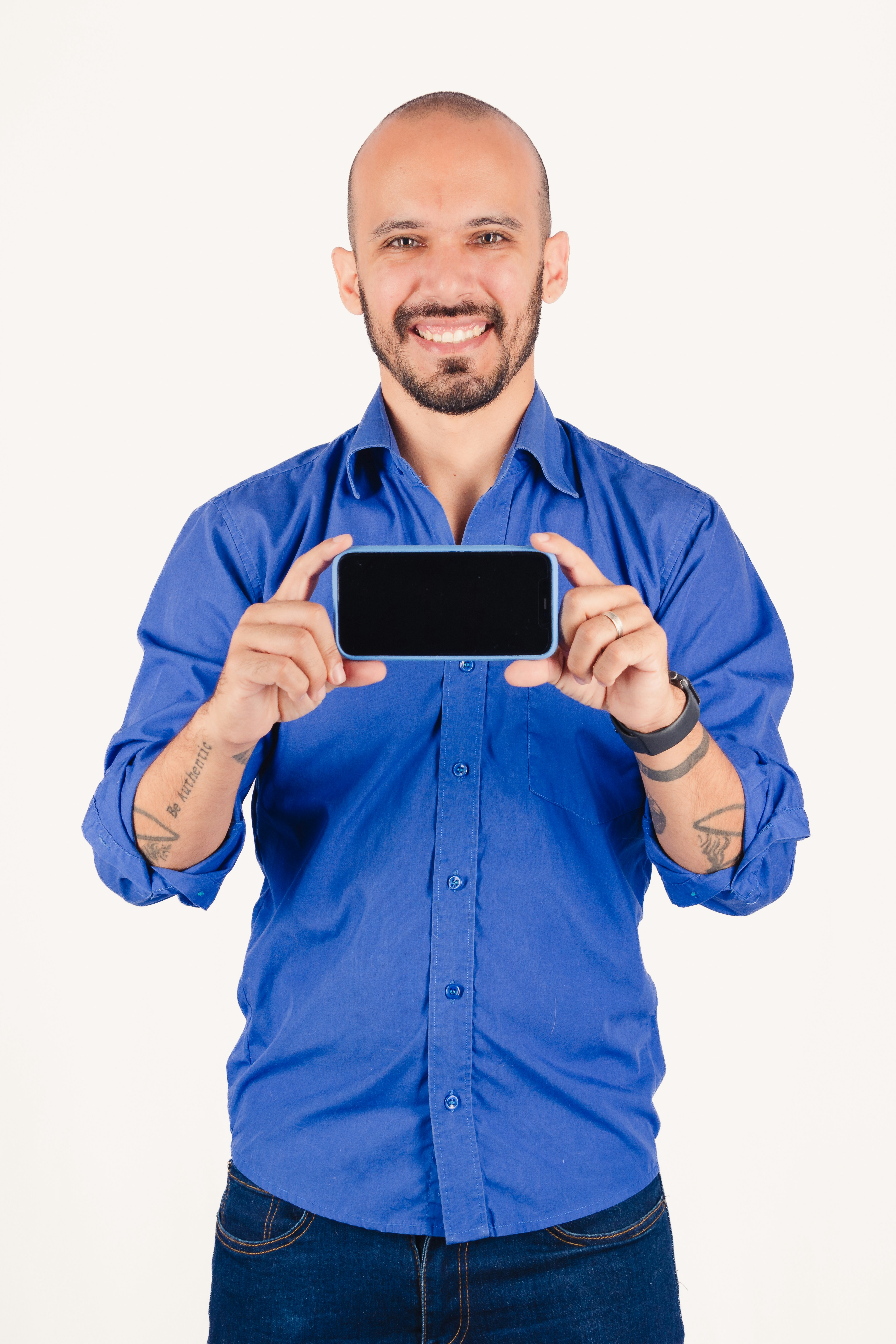 Man holding a smartphone with a blank screen.