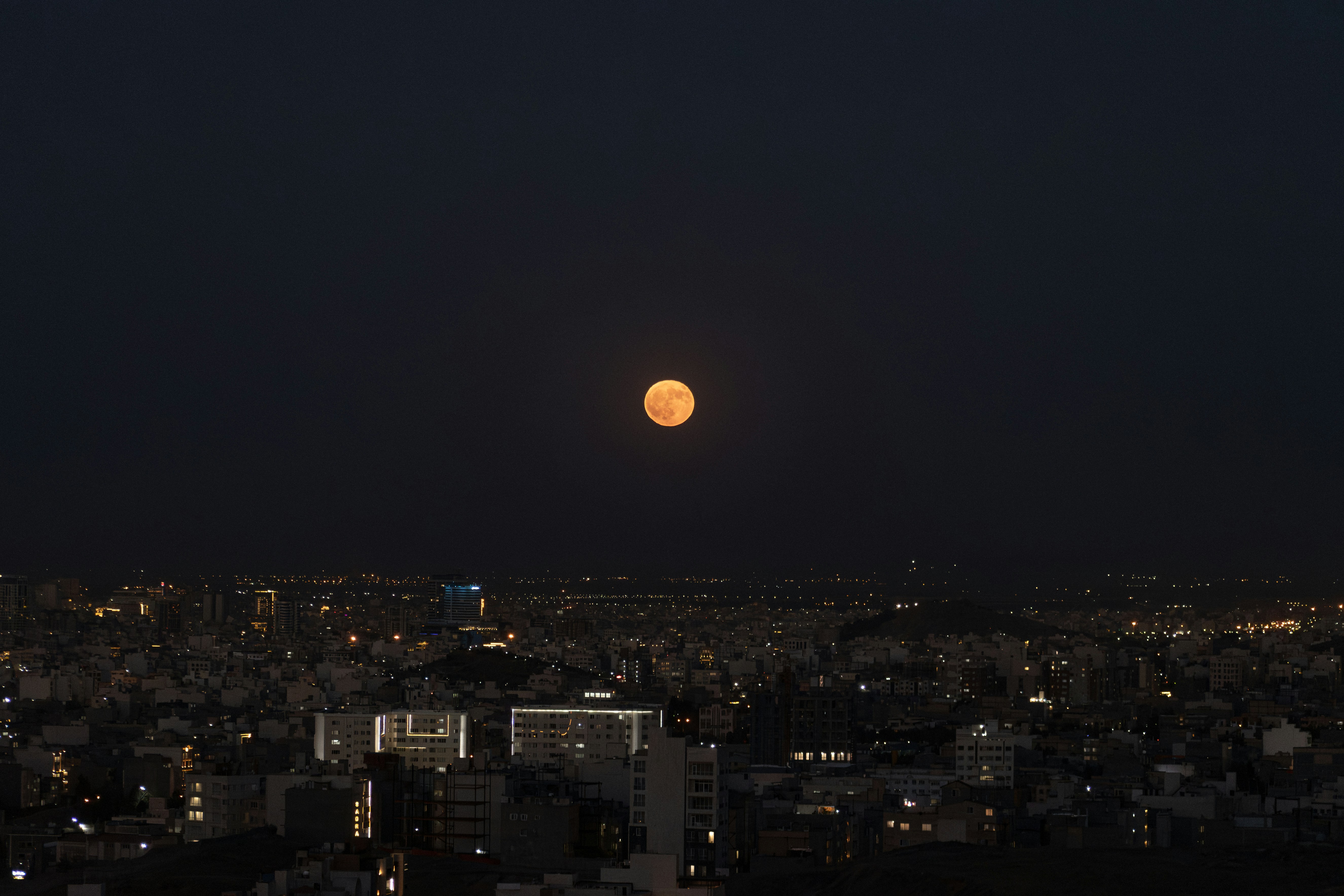 Full moon over a city at night