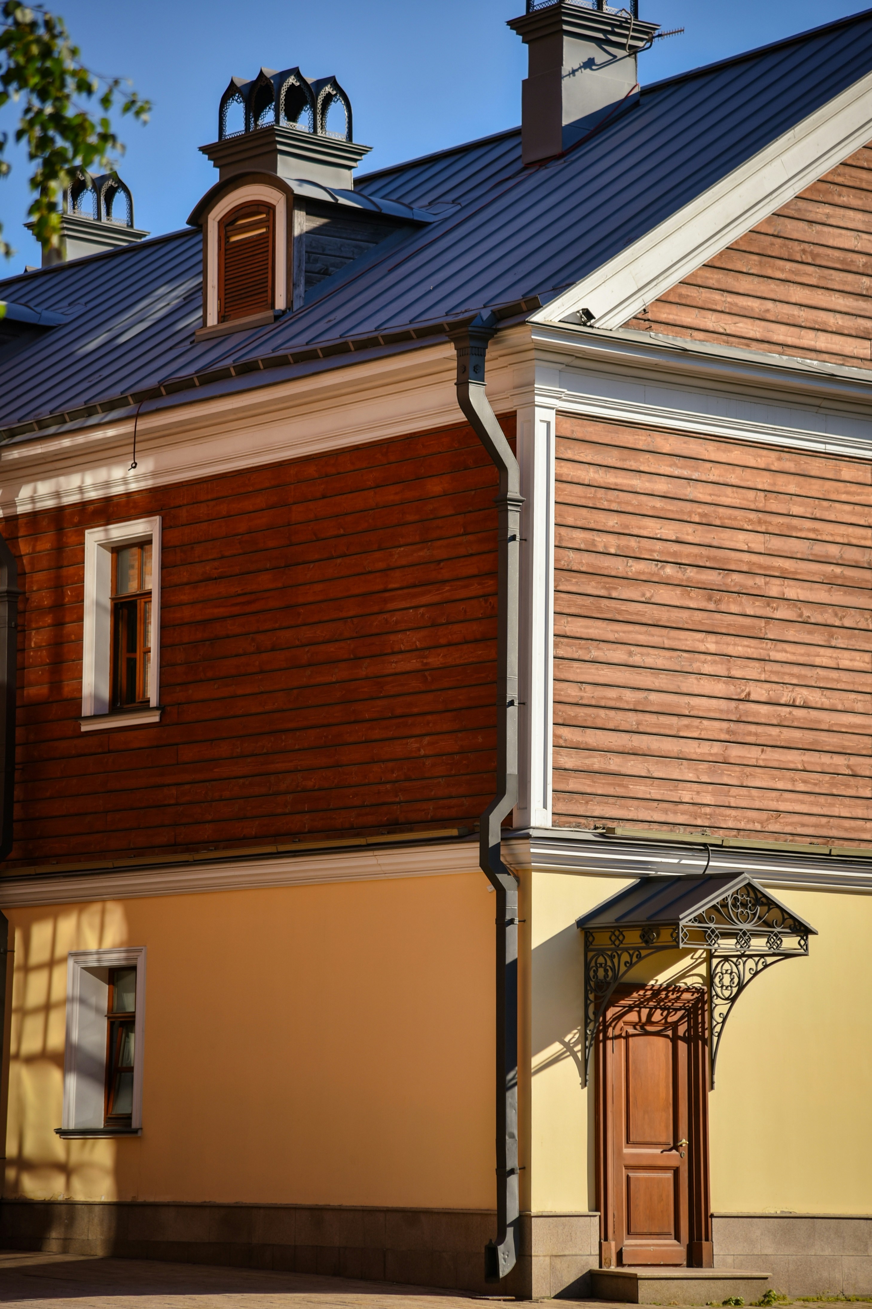 A beautifully crafted wooden and stucco building featuring intricate architectural details and a welcoming entrance. The interplay of materials and colors highlights the design's elegance.