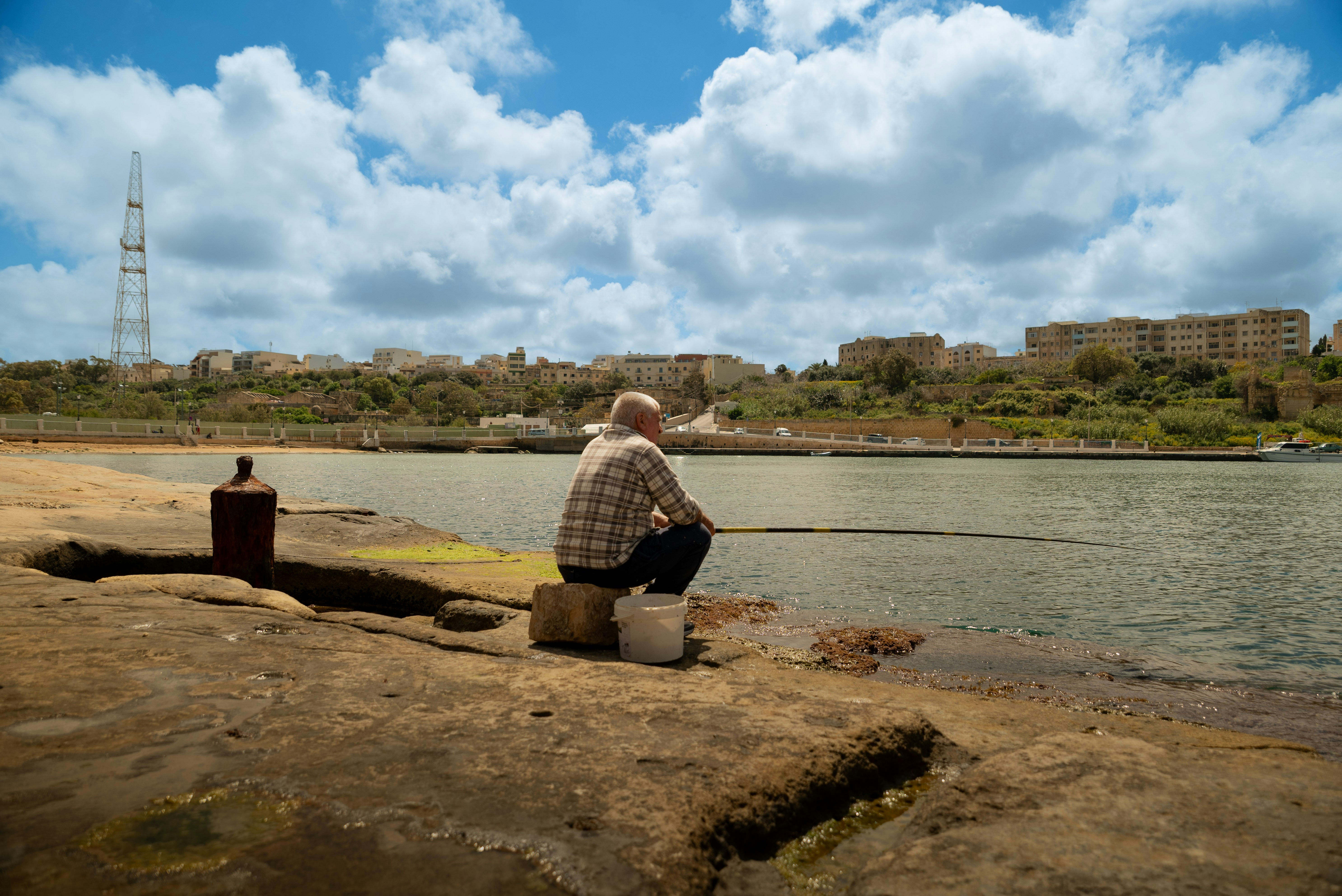 The Quiet Angler by a Broad Riverbank