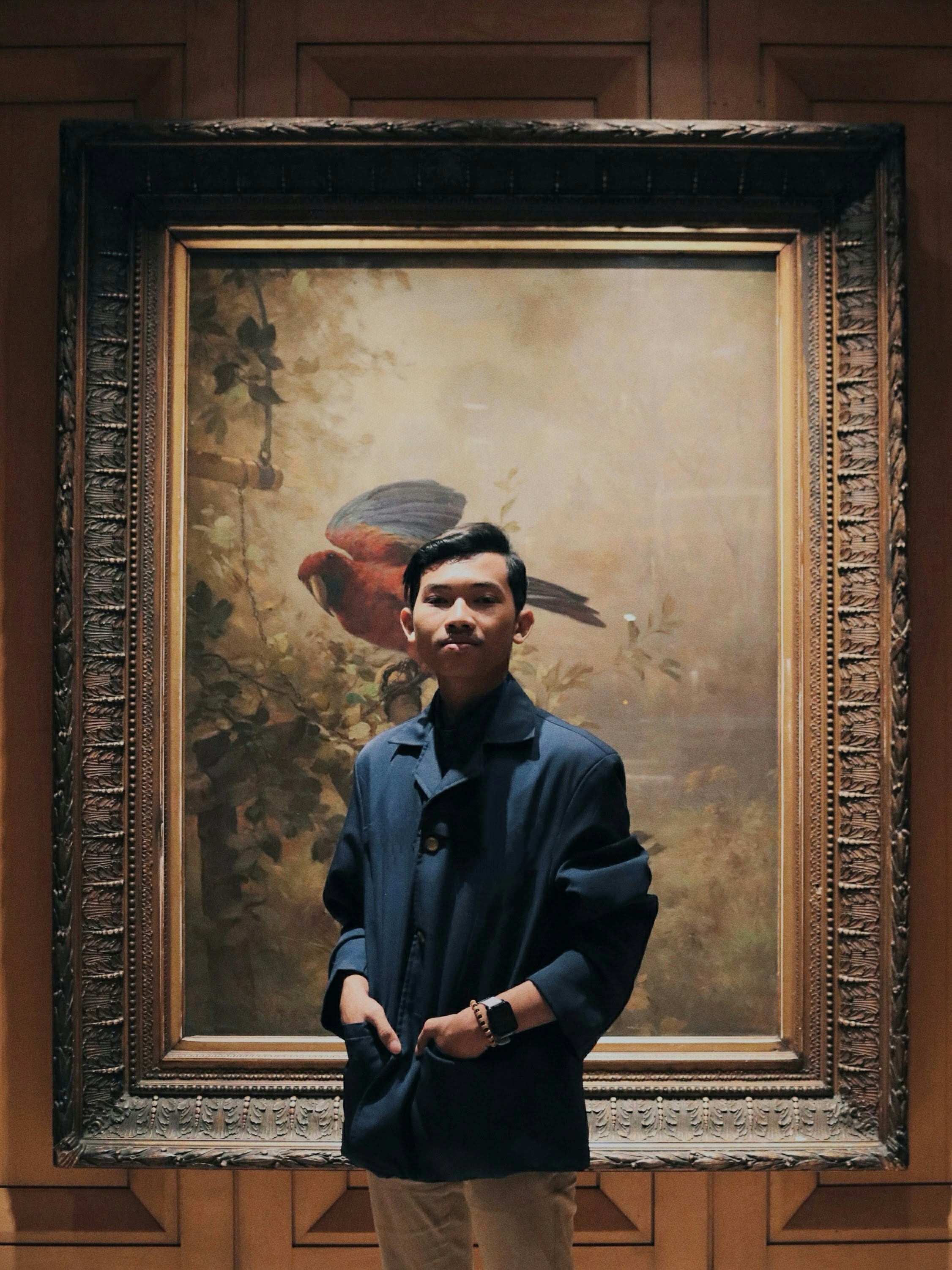 Man stands in front of a framed bird painting