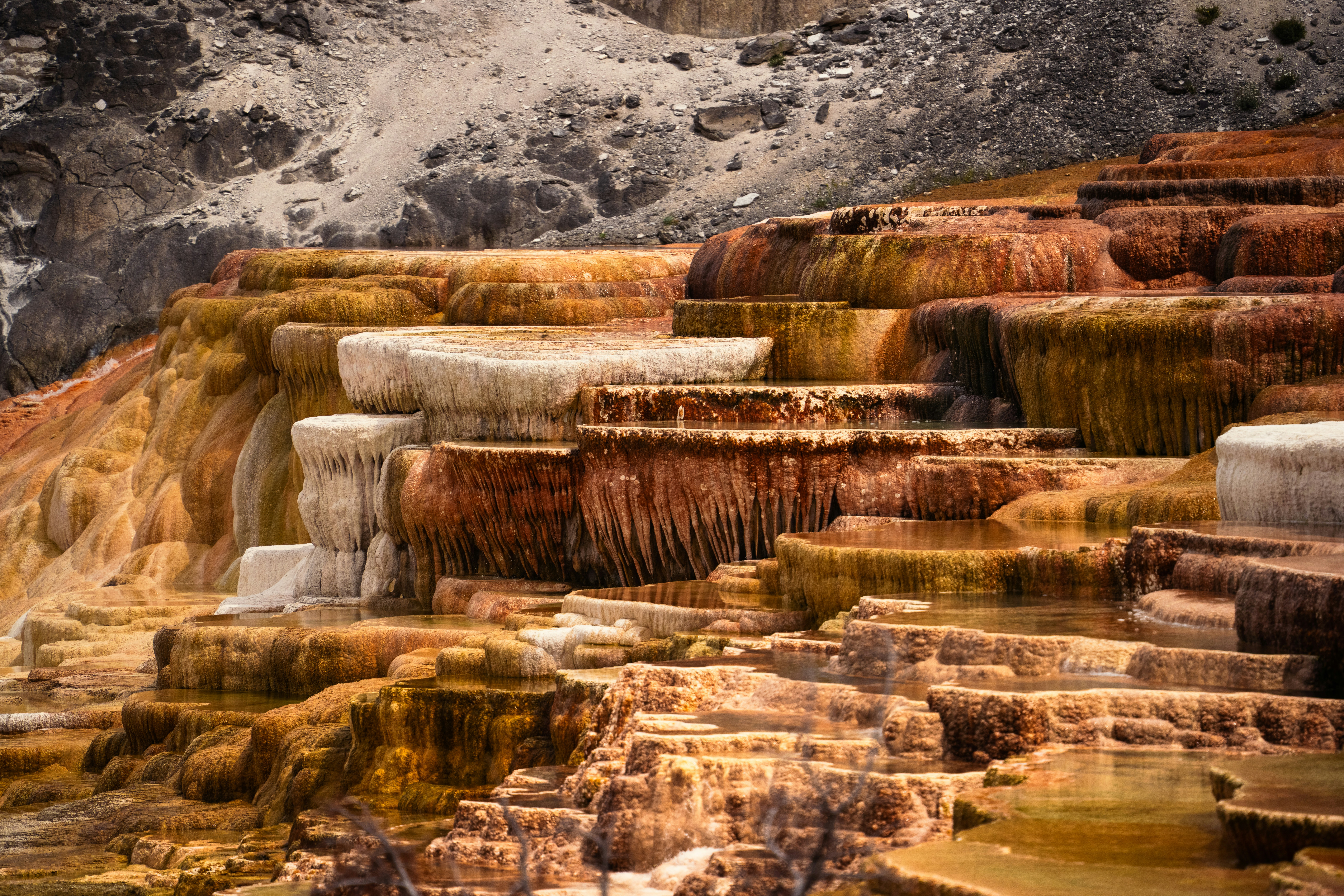 Colorful mineral terraces formed by geothermal activity, showcasing vibrant hues and intricate patterns. Natural wonder highlighting the beauty of geological processes.