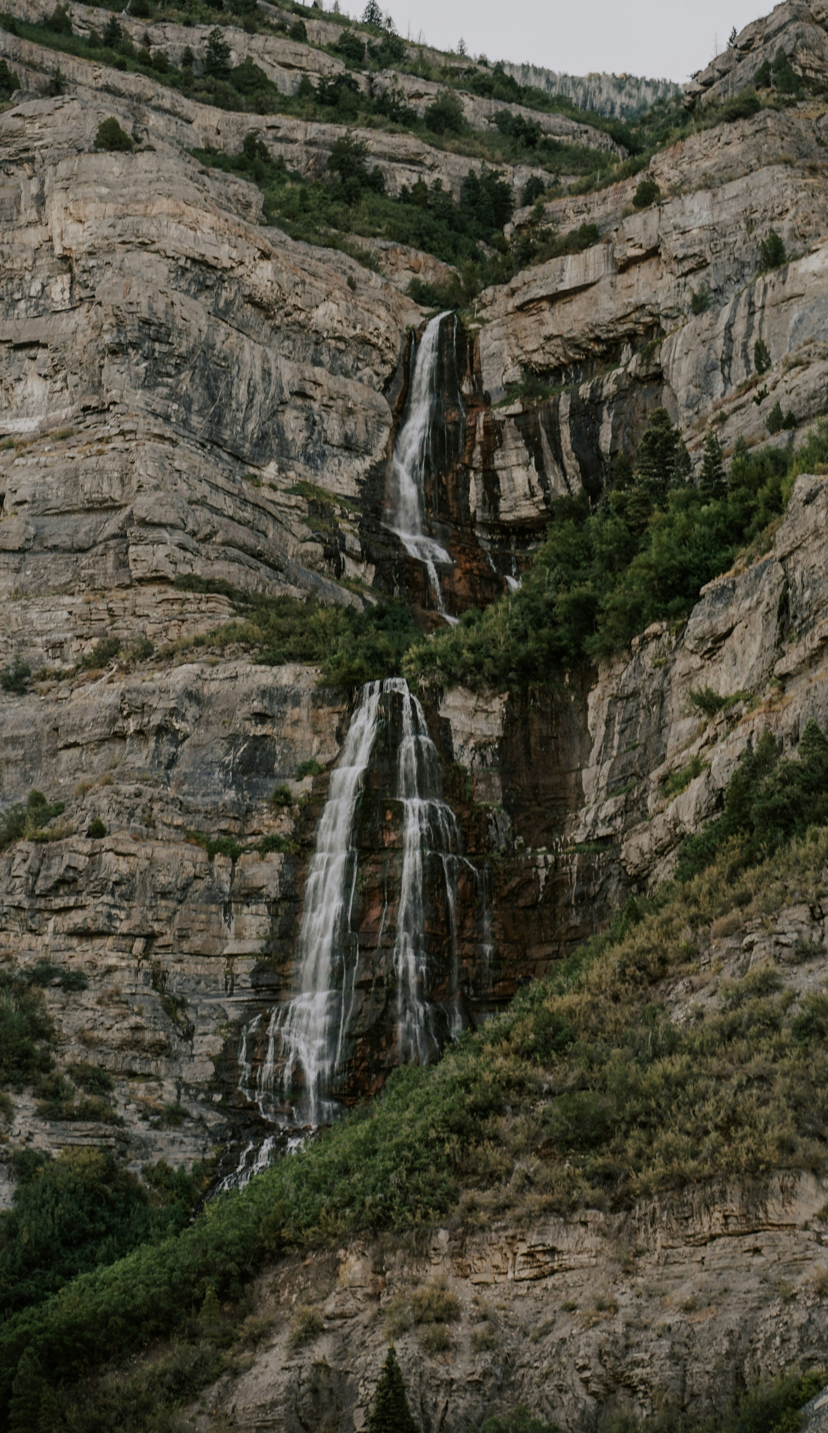 Cascading waterfalls flow down a rocky mountainside