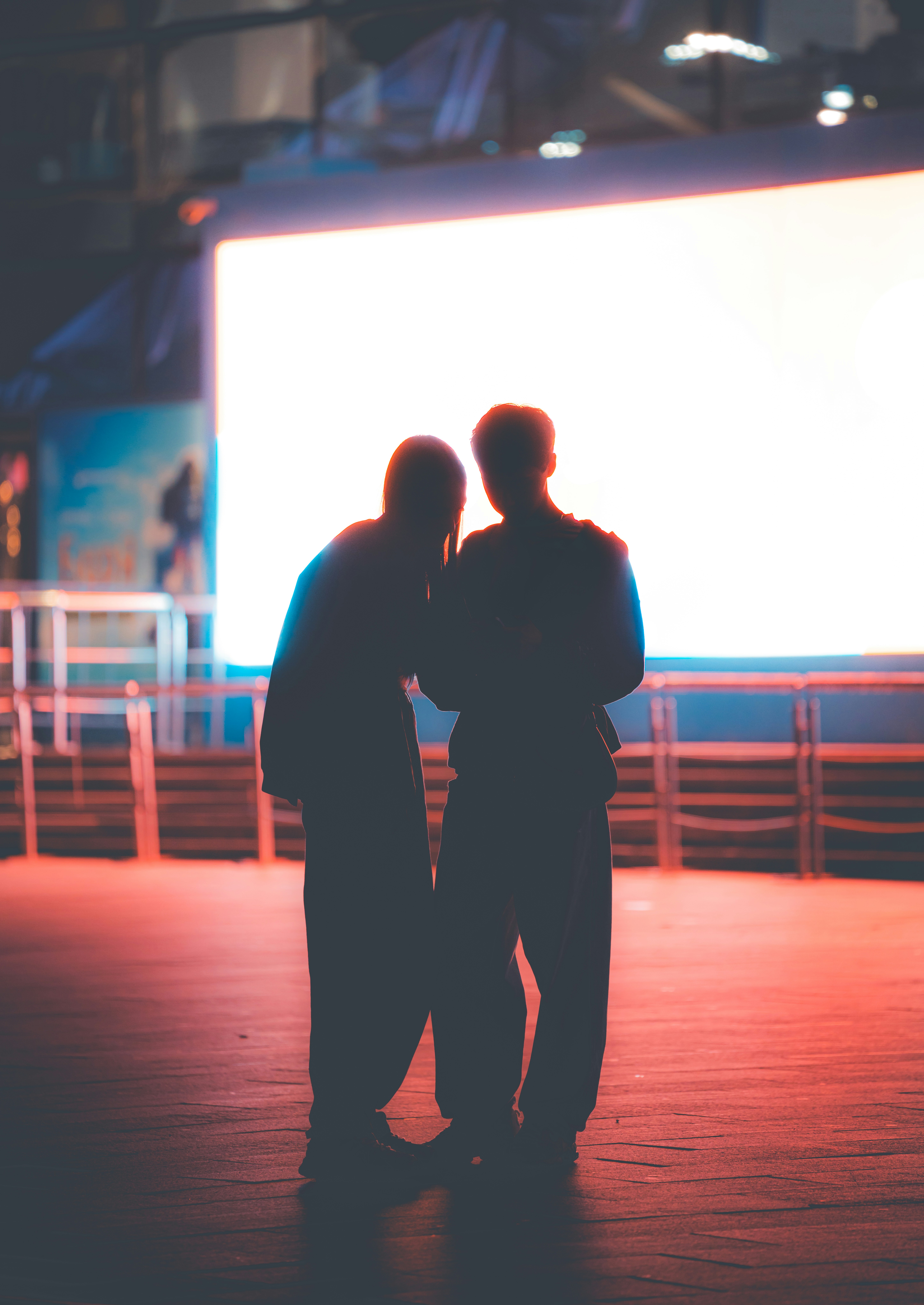 Two people stand before a bright, glowing screen. photo – Free Street ...