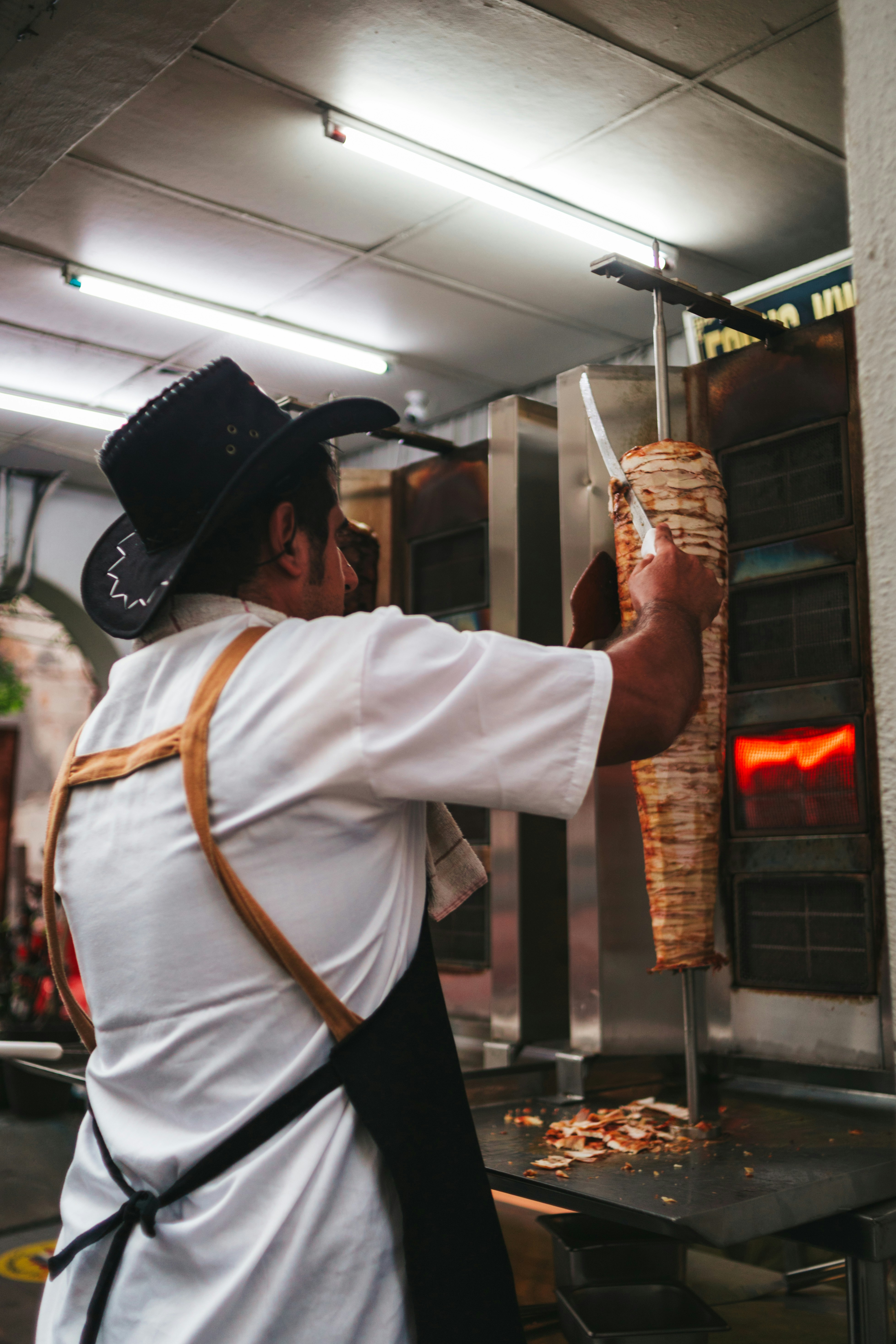 Chef preparing meat on a vertical rotisserie