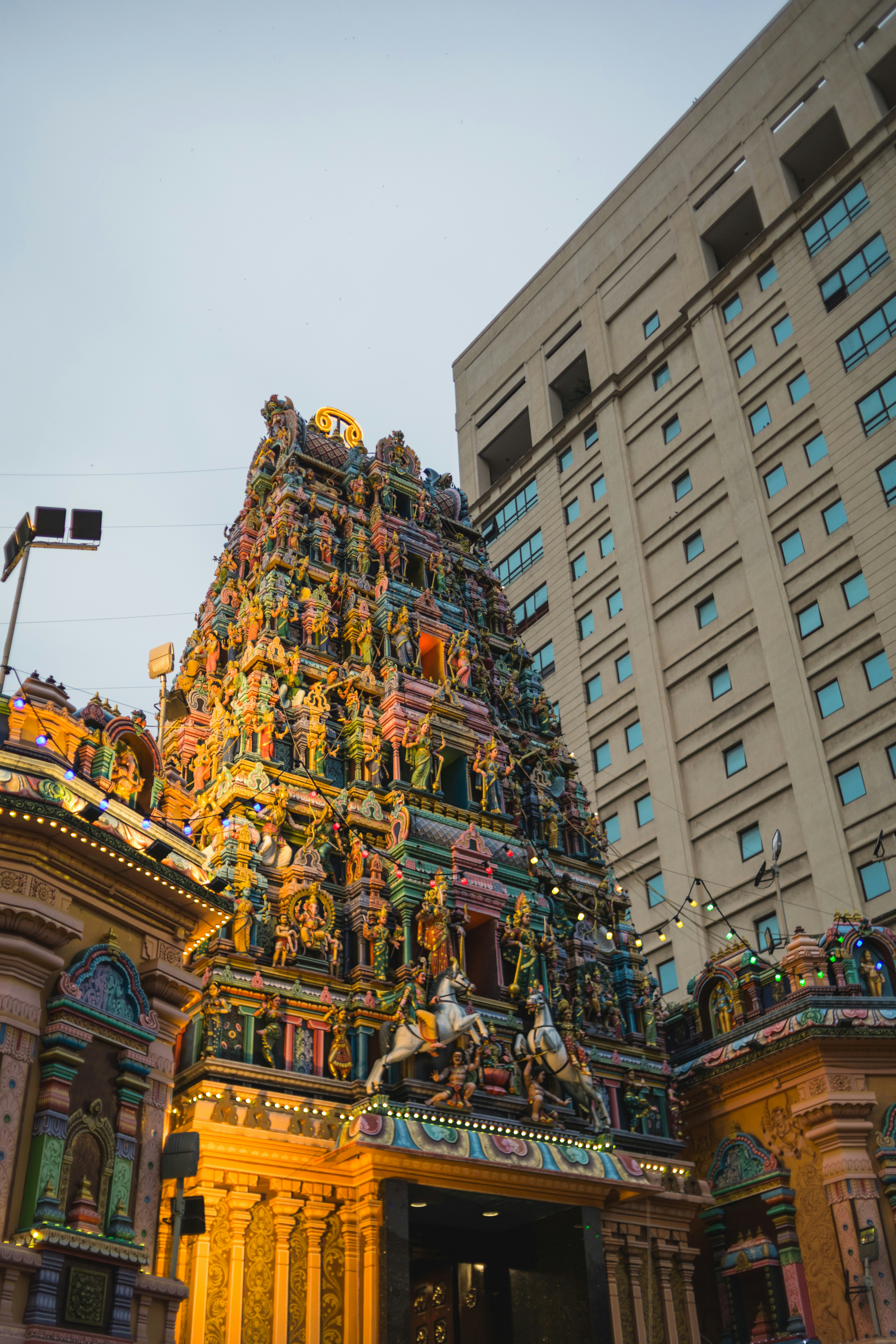 Ornate hindu temple tower next to modern building