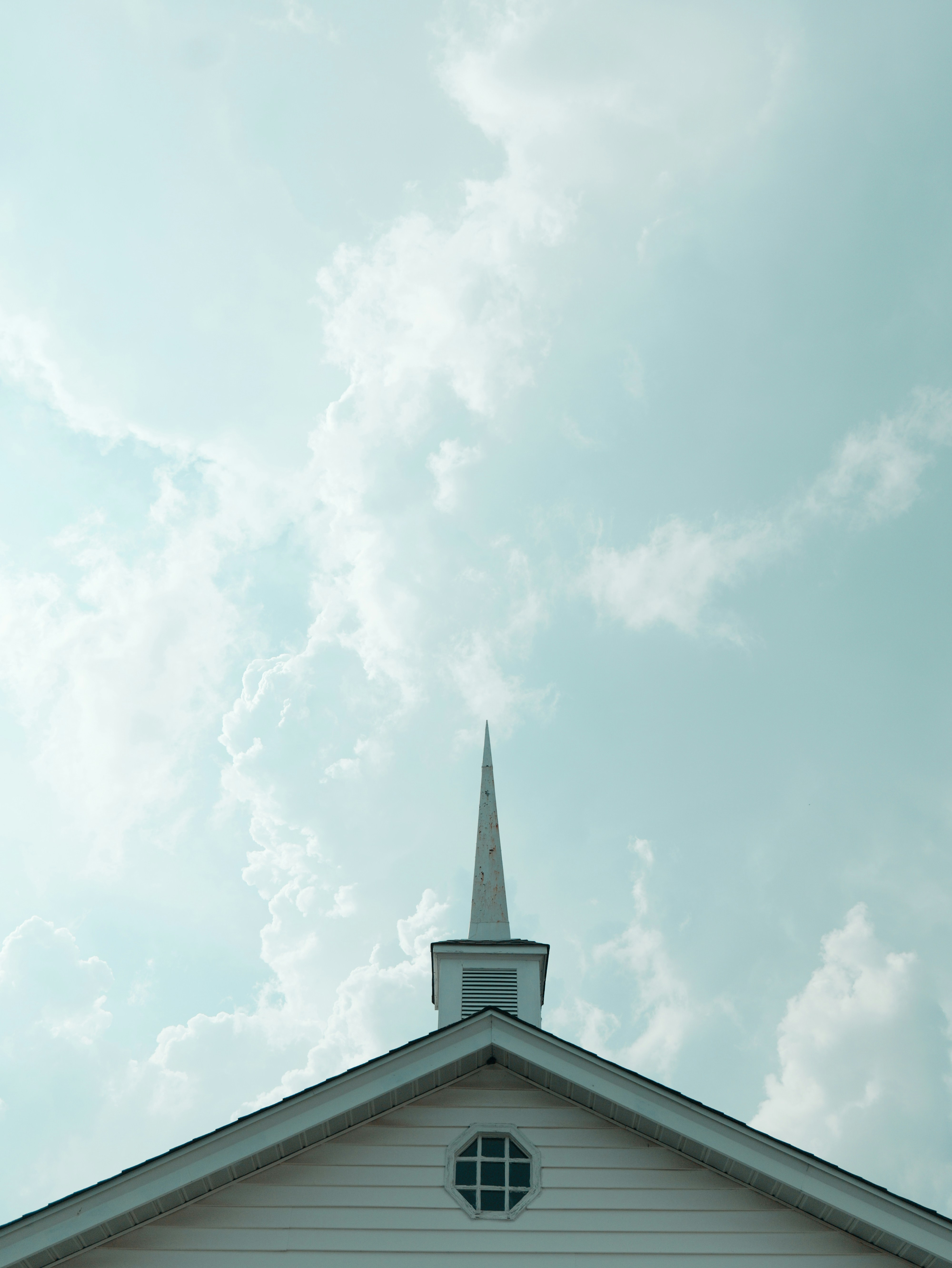 White steeple on a building against a cloudy sky