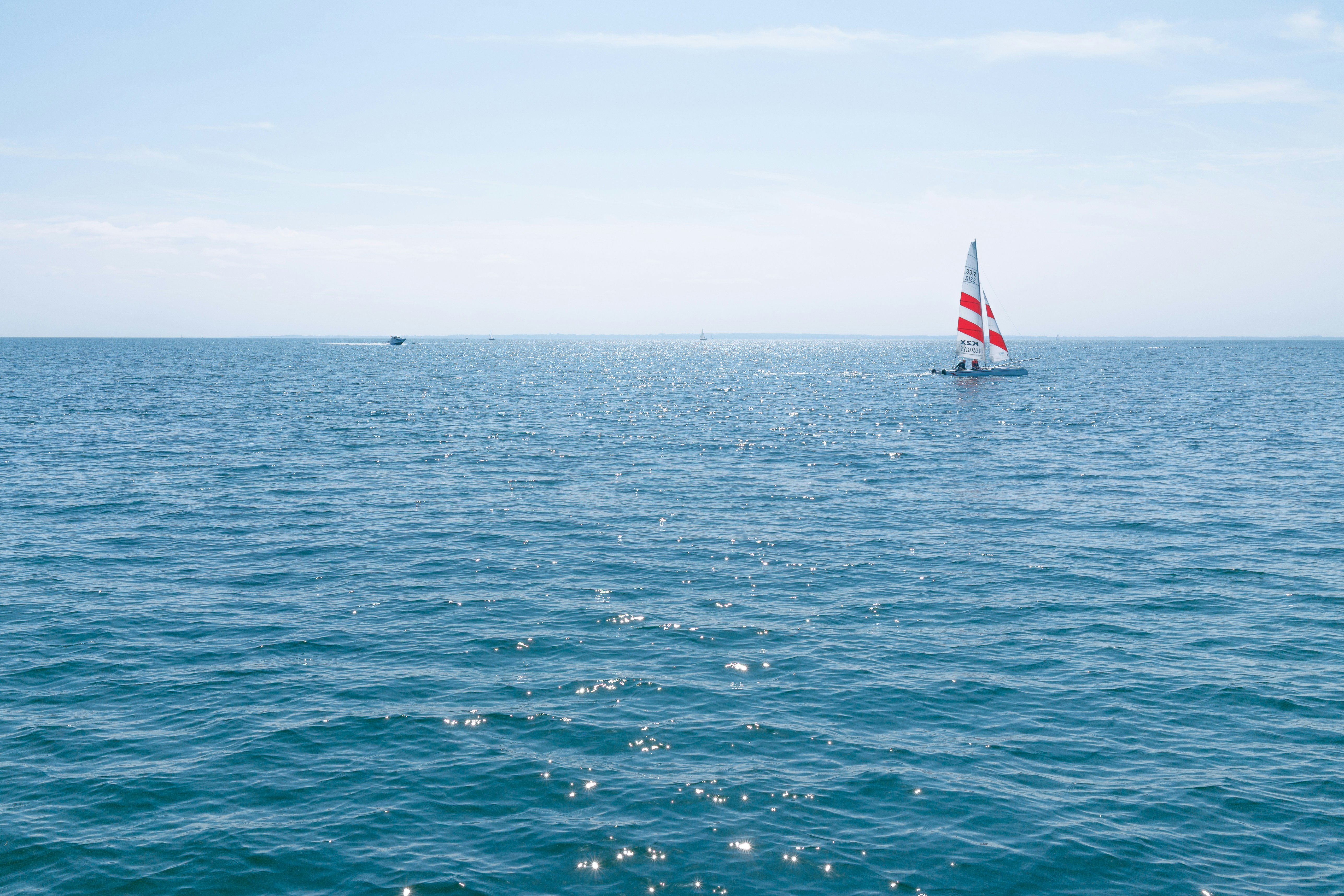 Un velero solitario se desliza por el vasto océano azul. foto – Imagen ...