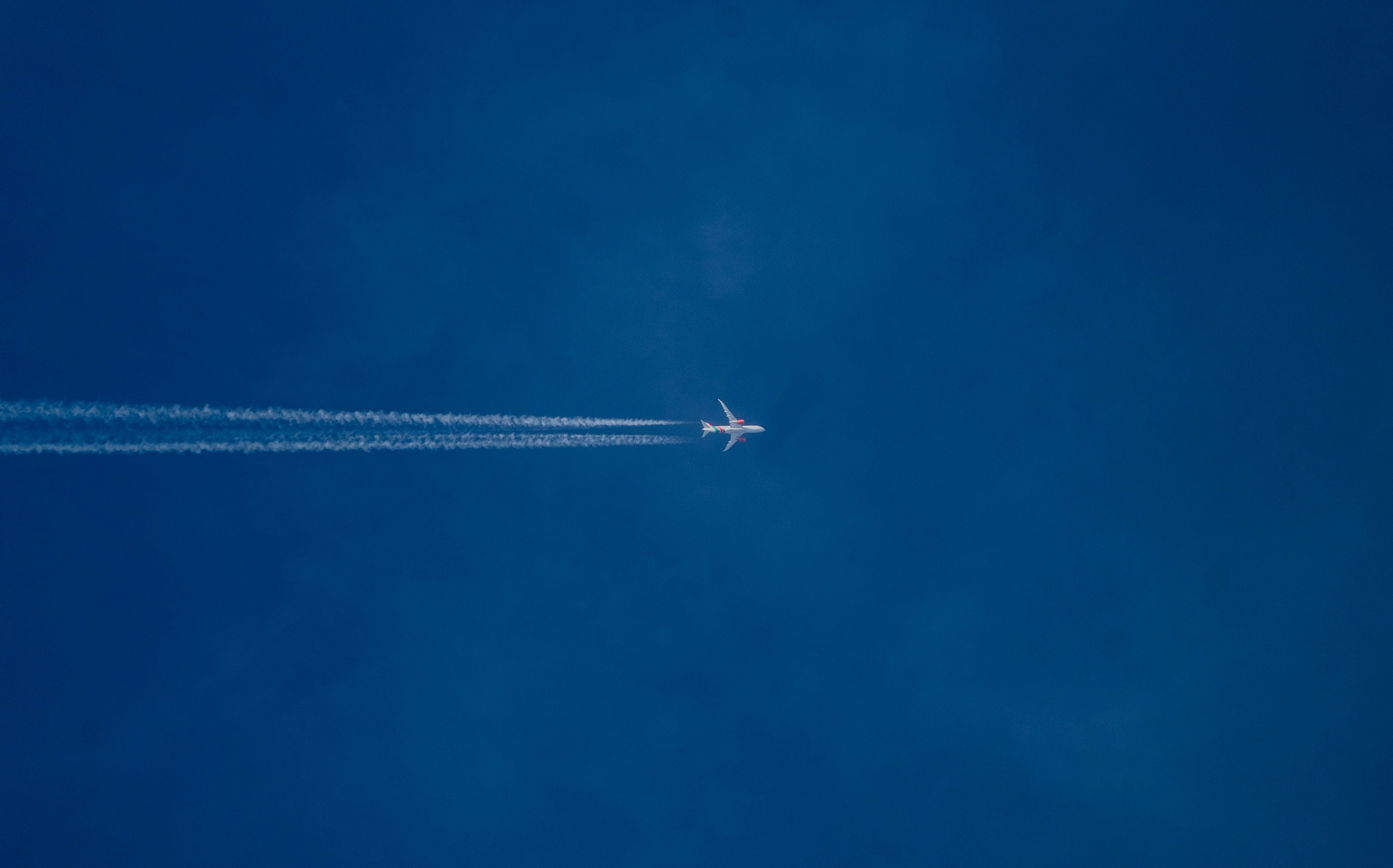 Airplane leaving a contrail across a clear blue sky