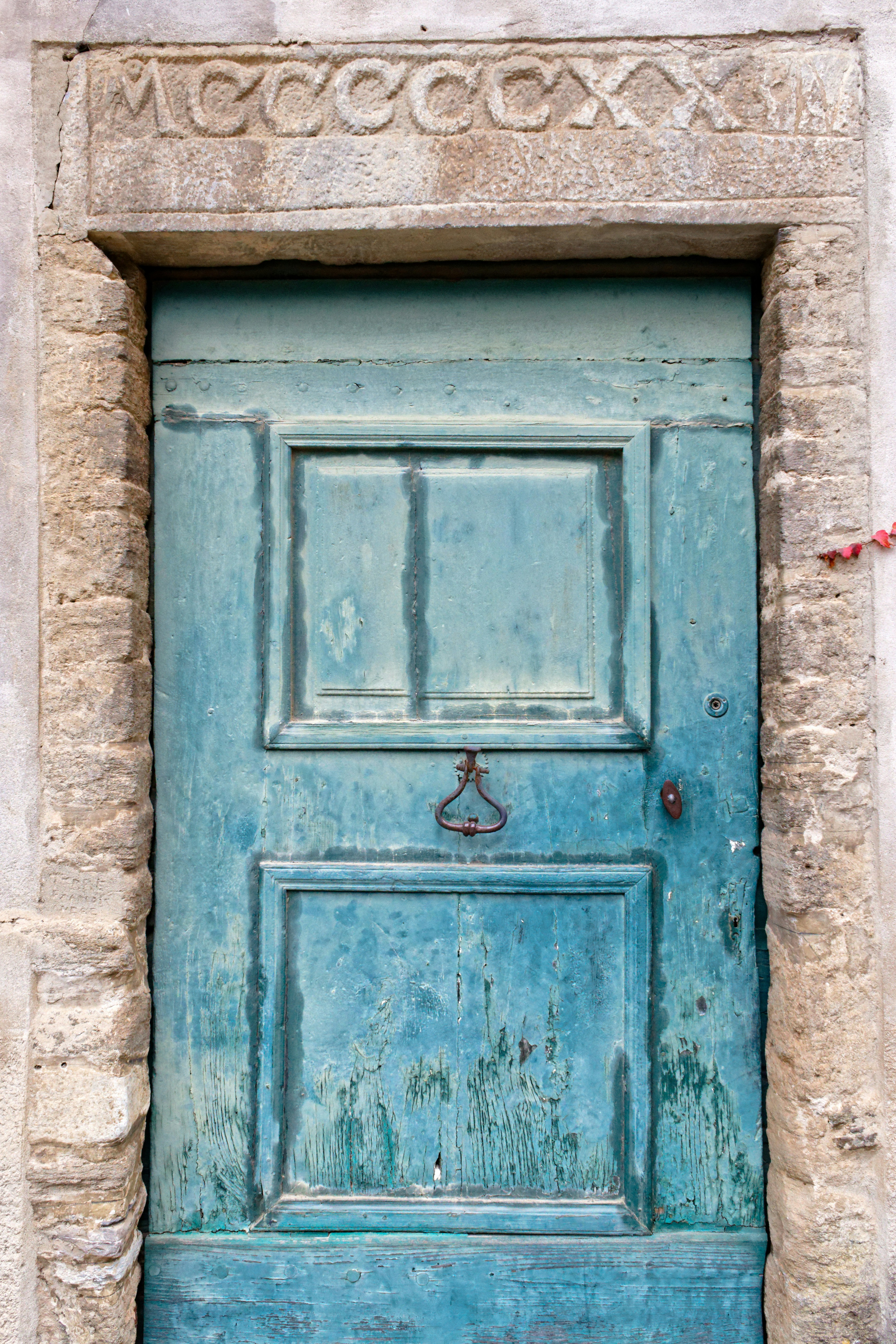 Old teal door with carved stone frame