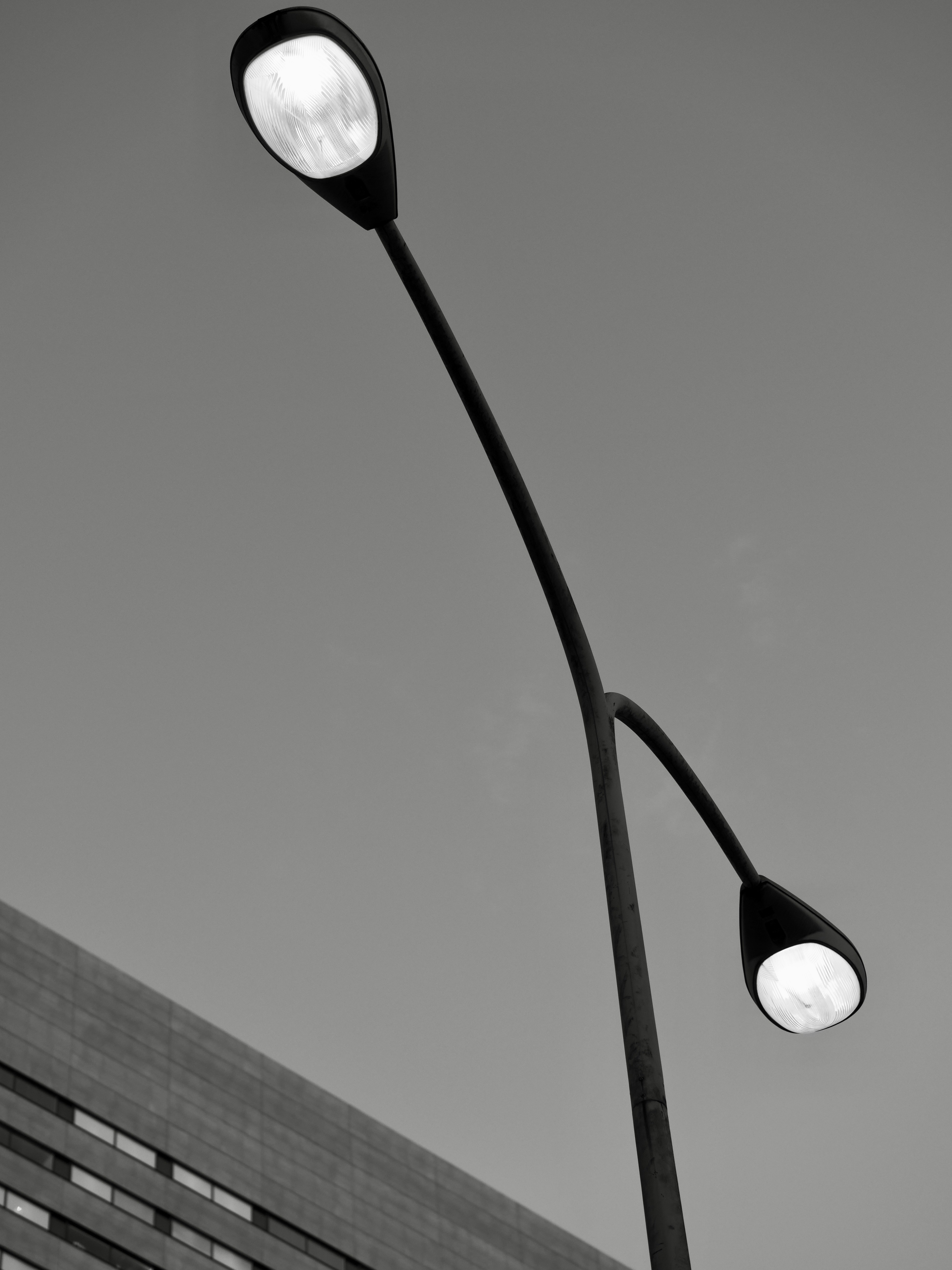 Streetlights | Two modern streetlights against a gray sky