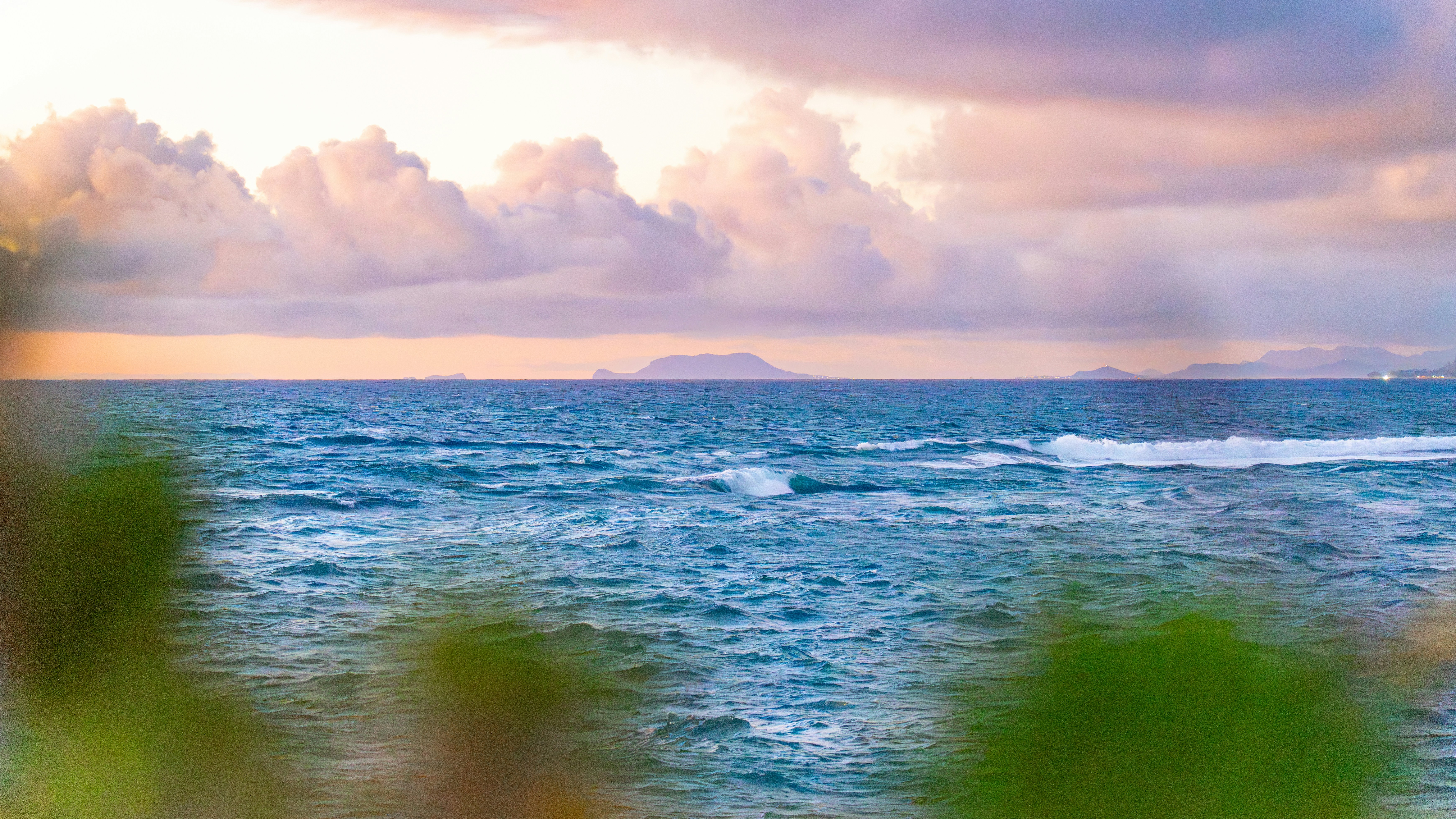 Ocean waves under a colorful cloudy sky