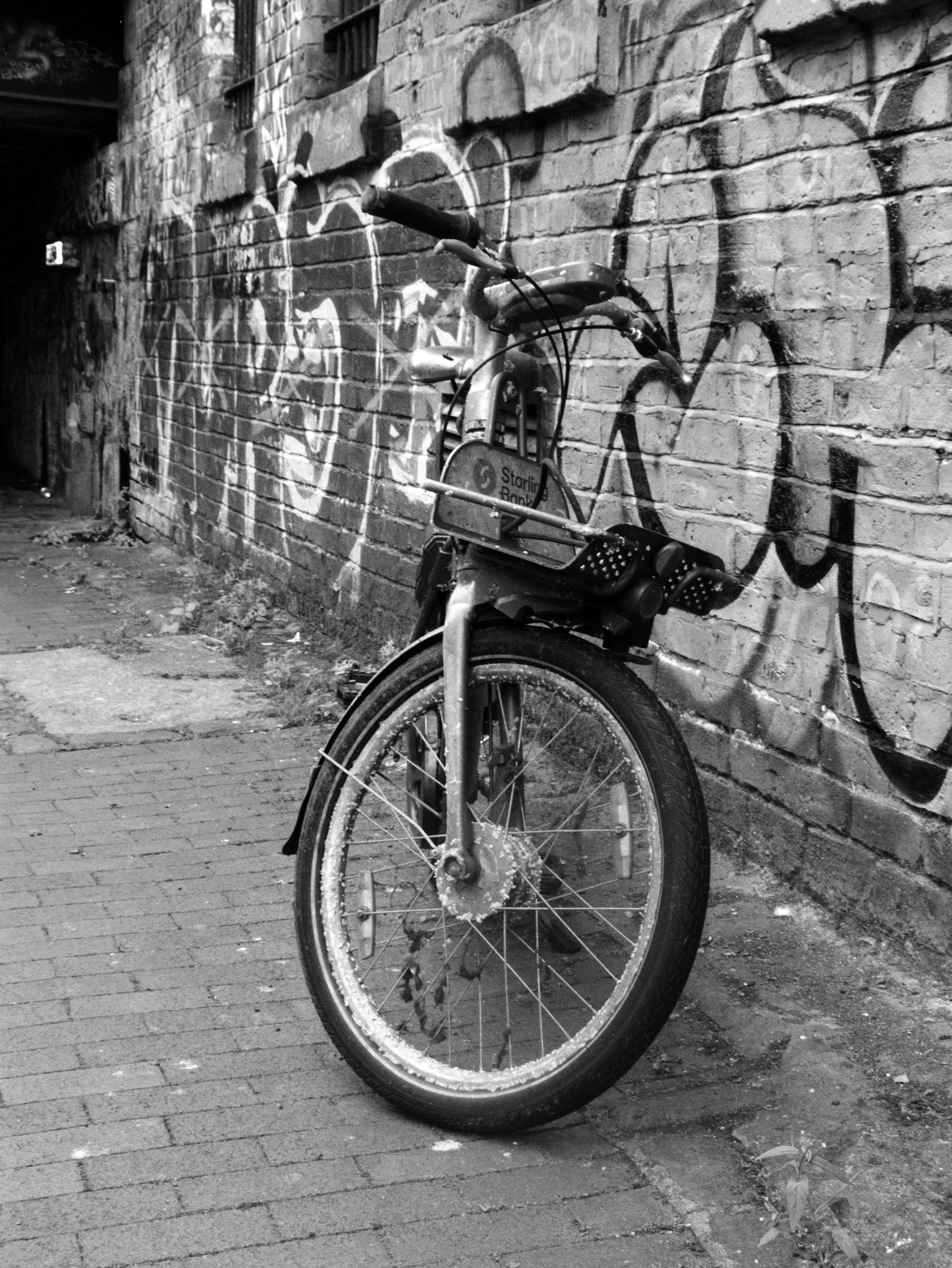 Motorcycle parked against graffiti wall