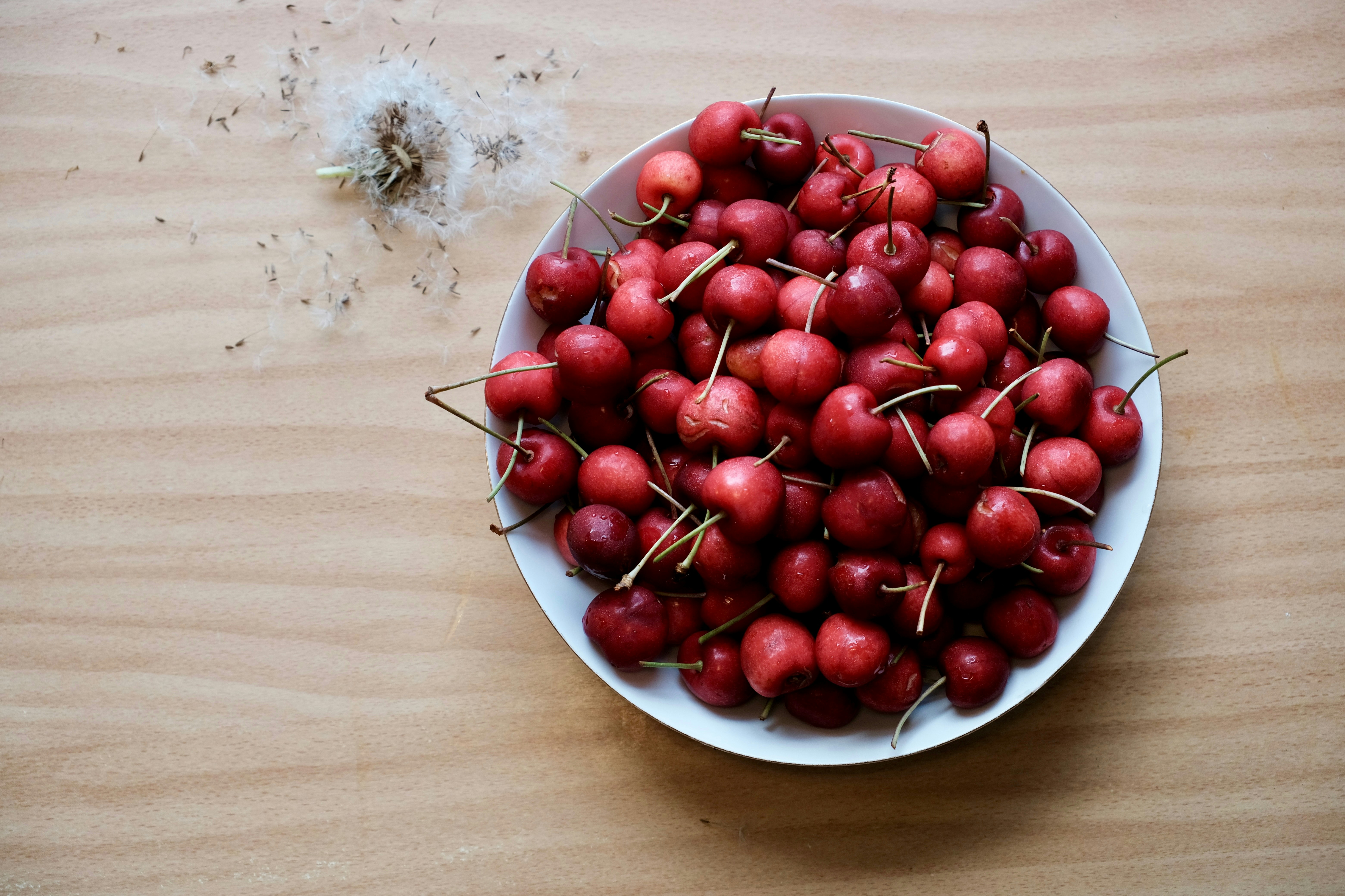 Bowl of fresh radishes on a wooden surface.