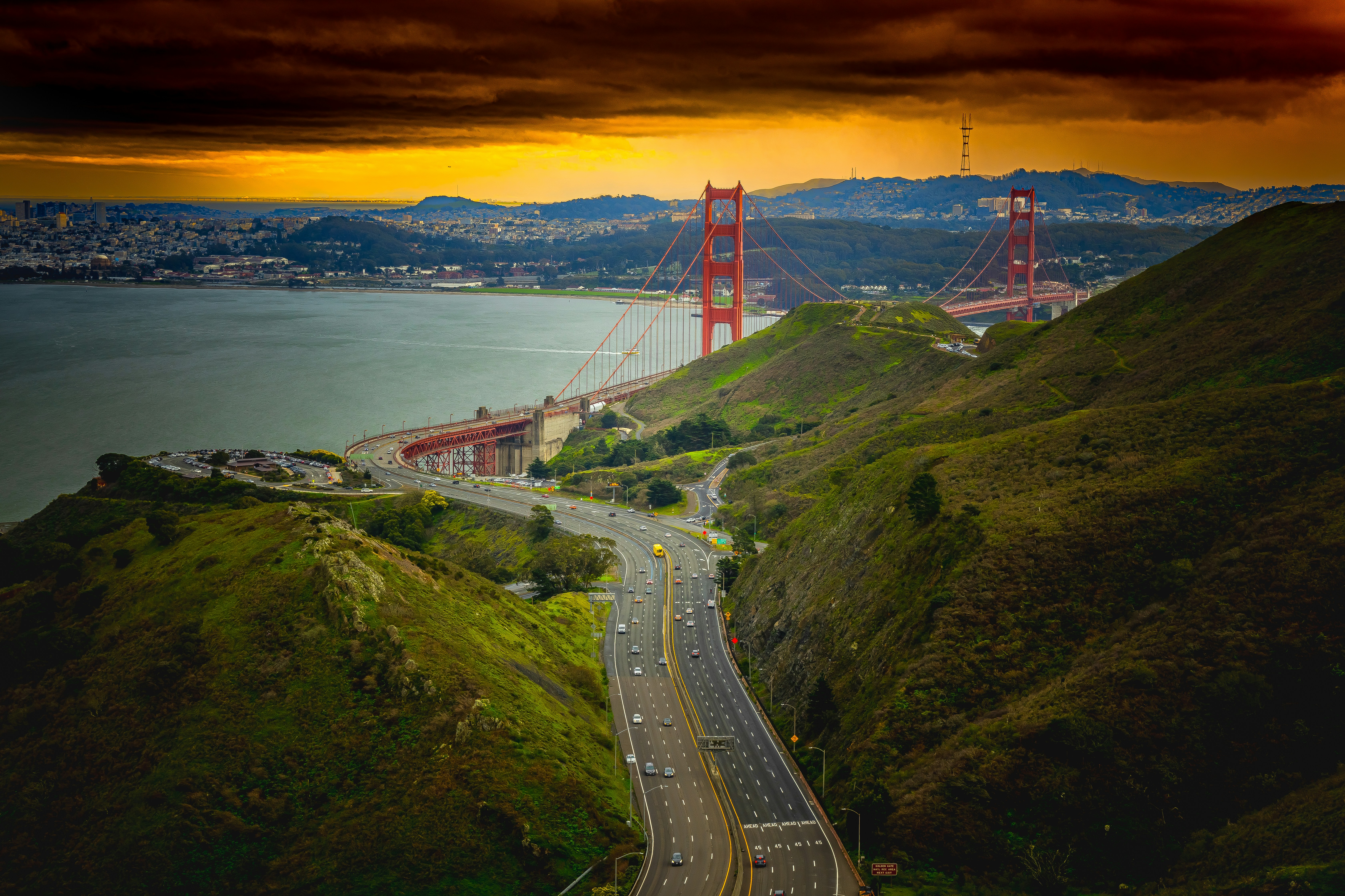 Scarlet Gate: A winding coastal road toward the Golden Gate Bridge at dusk